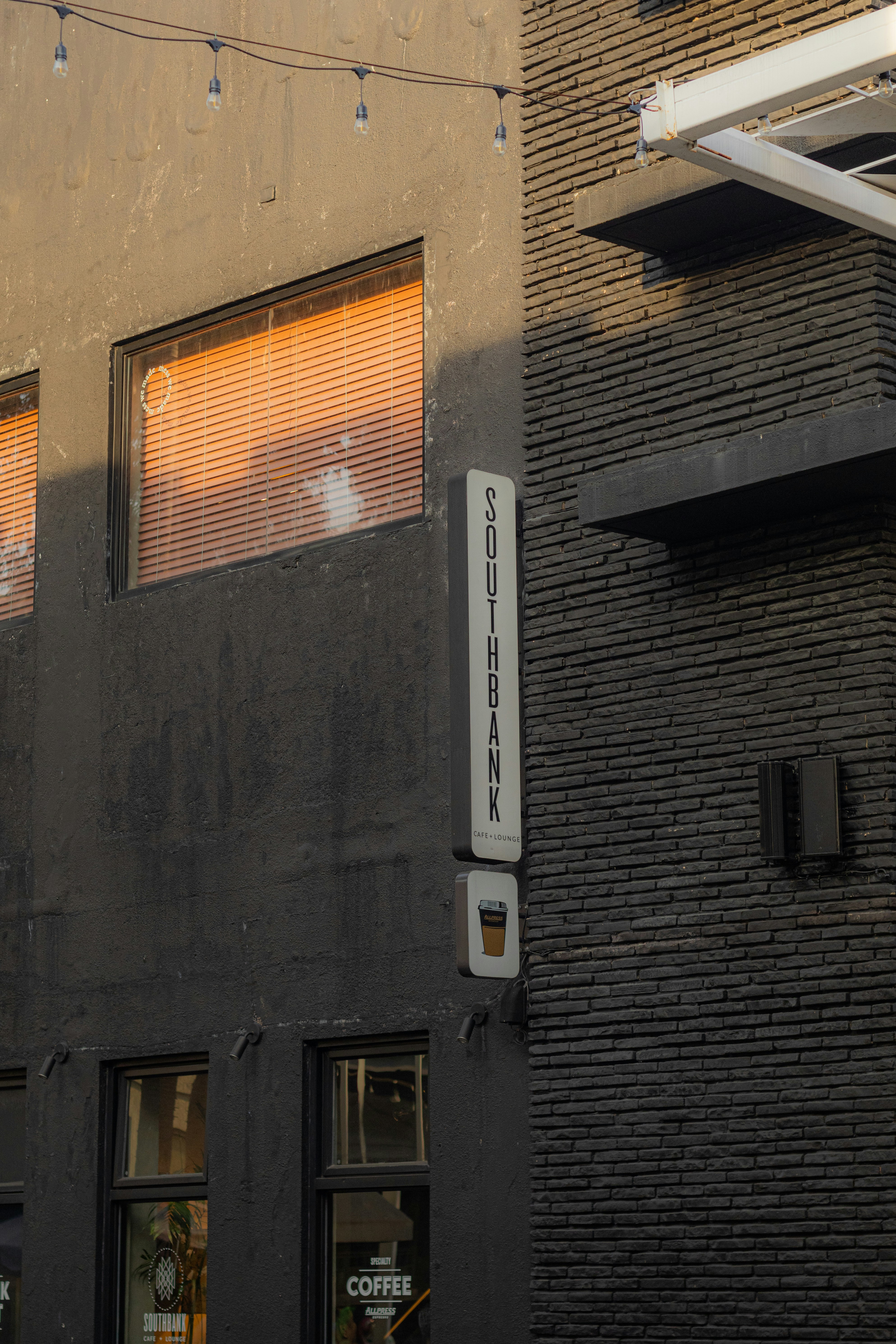 Vertical SOUTHBANK Sign Anchoring a Quiet Brick Corner in Warm Daylight