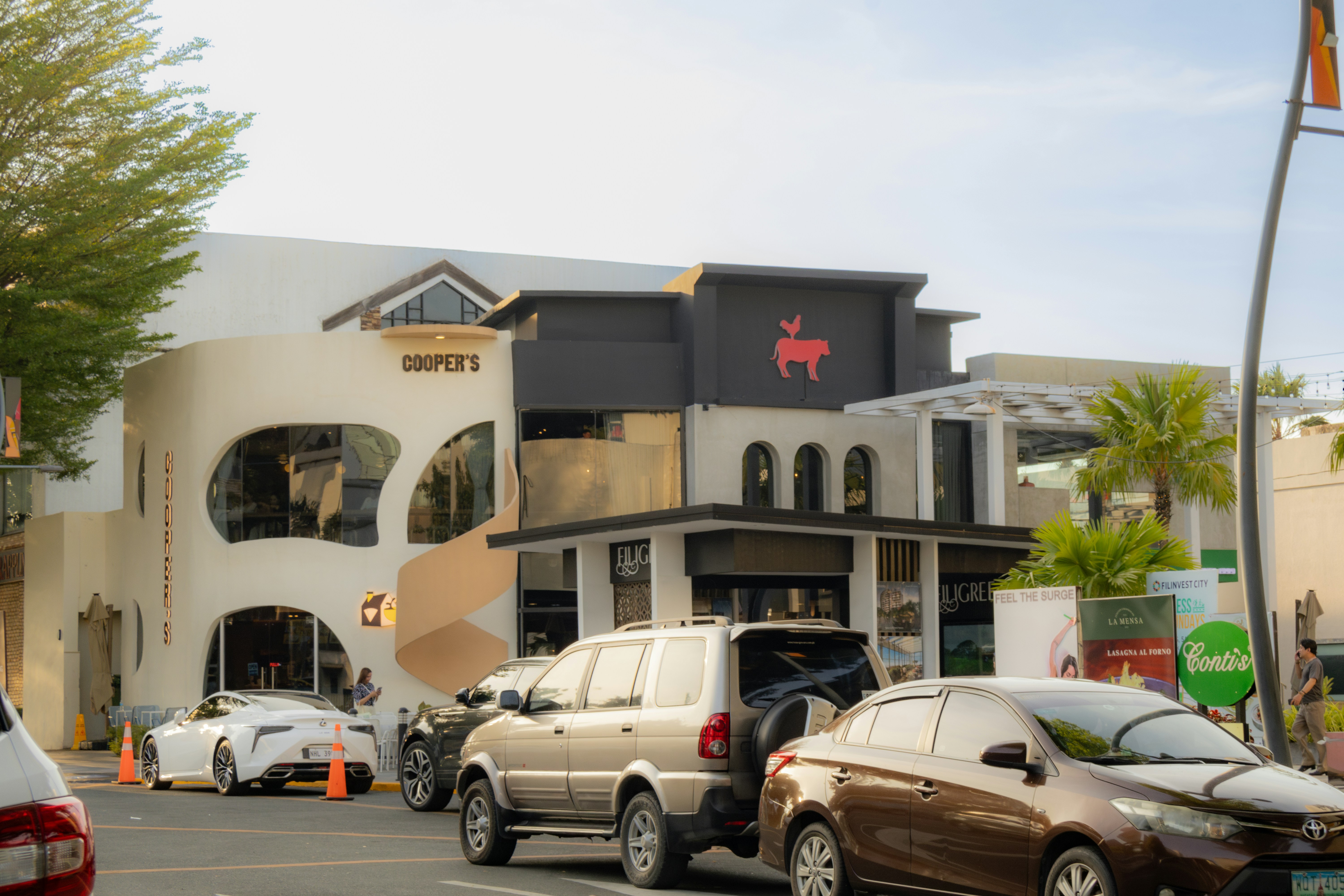 A restaurant with cars parked on the street. photo – Free City Image on ...