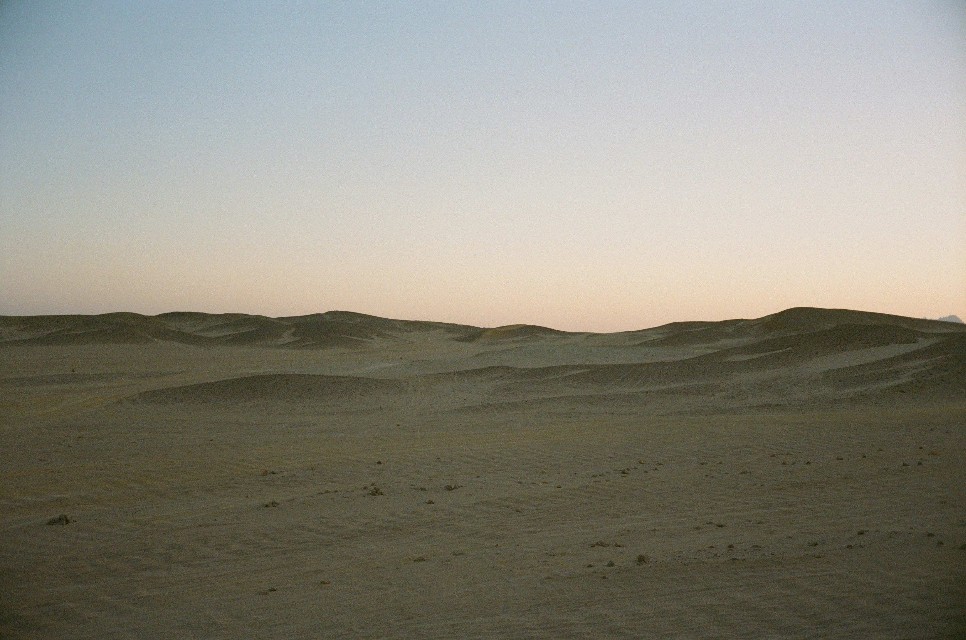 A vast desert landscape under a pale sky. photo – Free Desert Image on ...