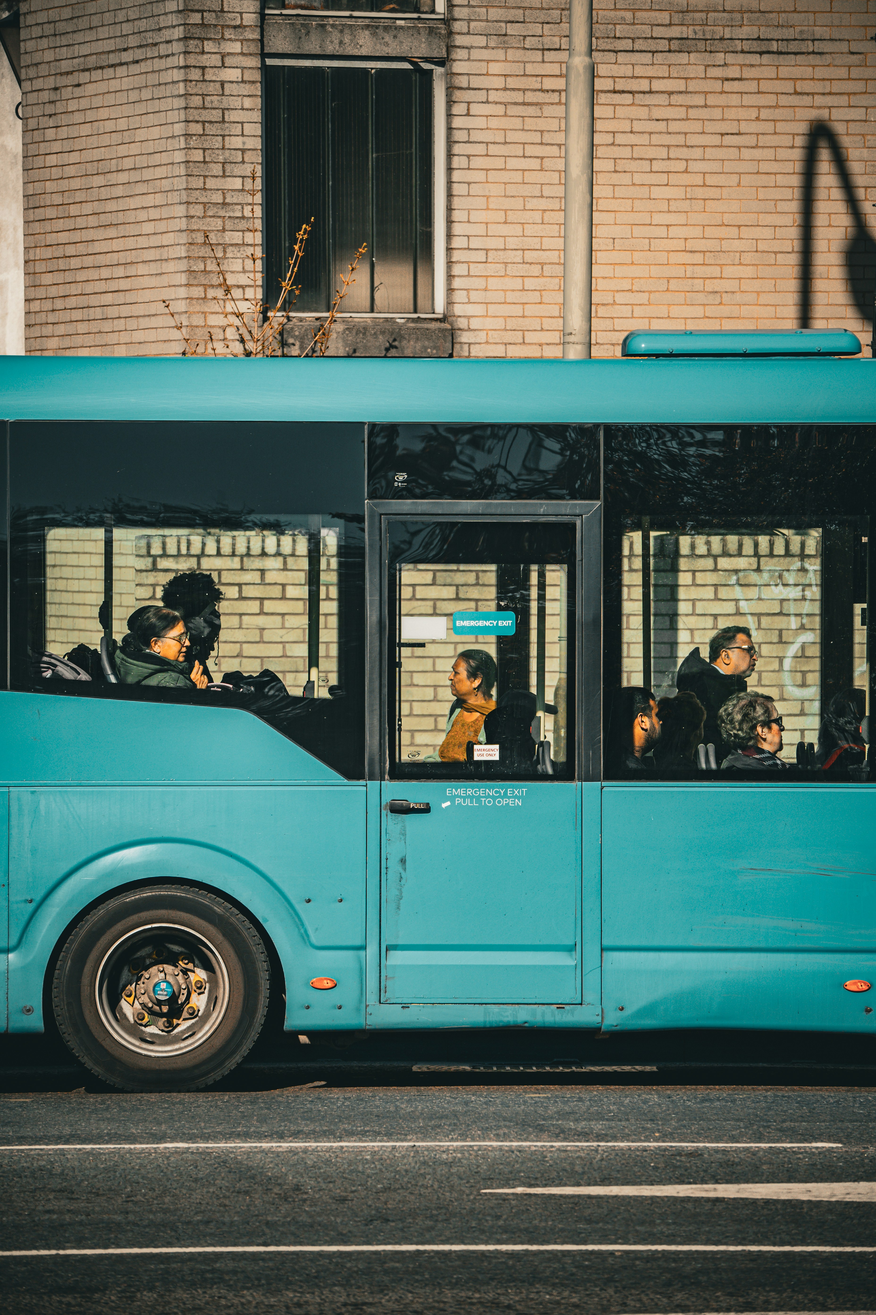A teal bus transports people in the city. photo – Free Human Image on ...