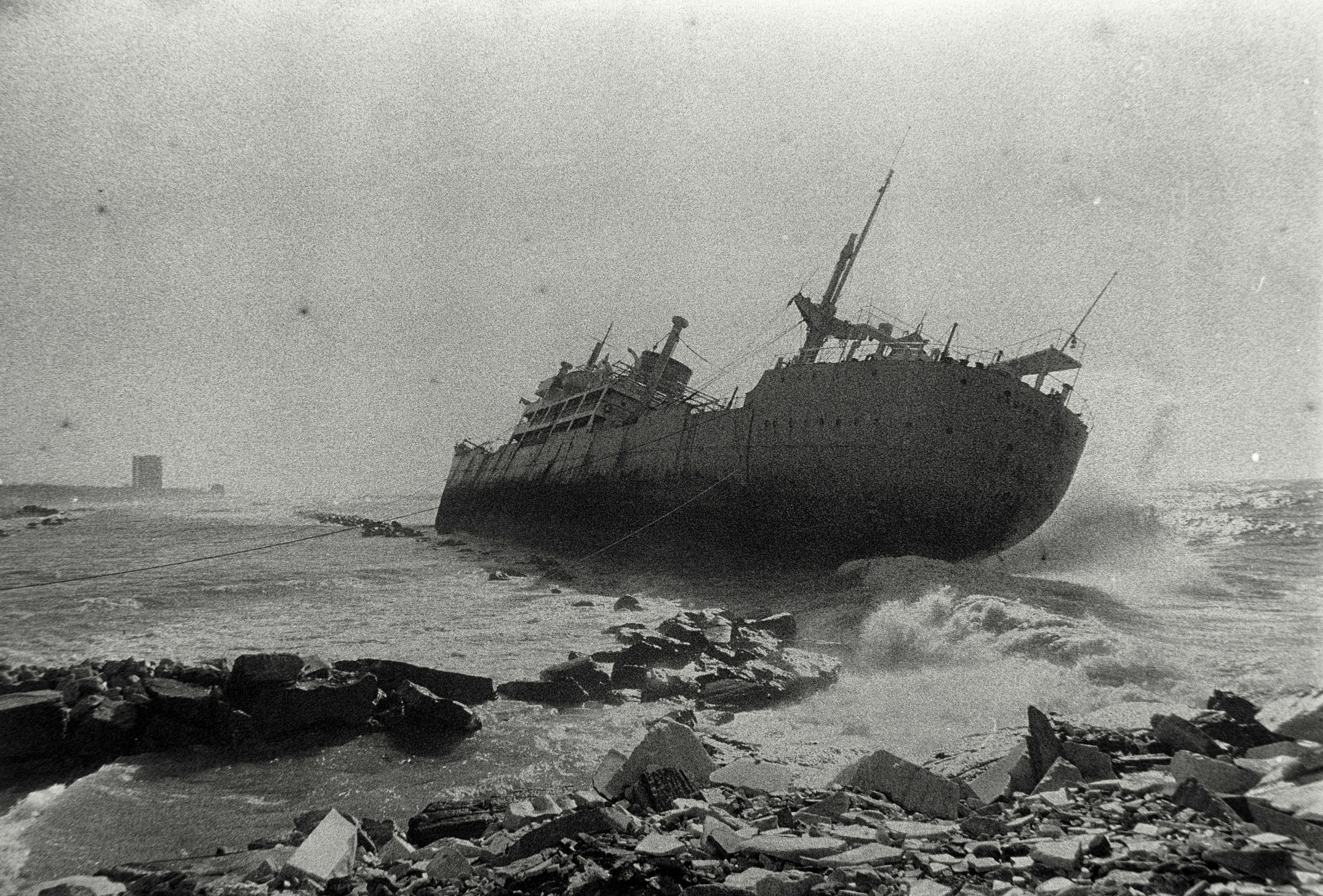 A large ship is beached by crashing waves. photo – Free Film ...