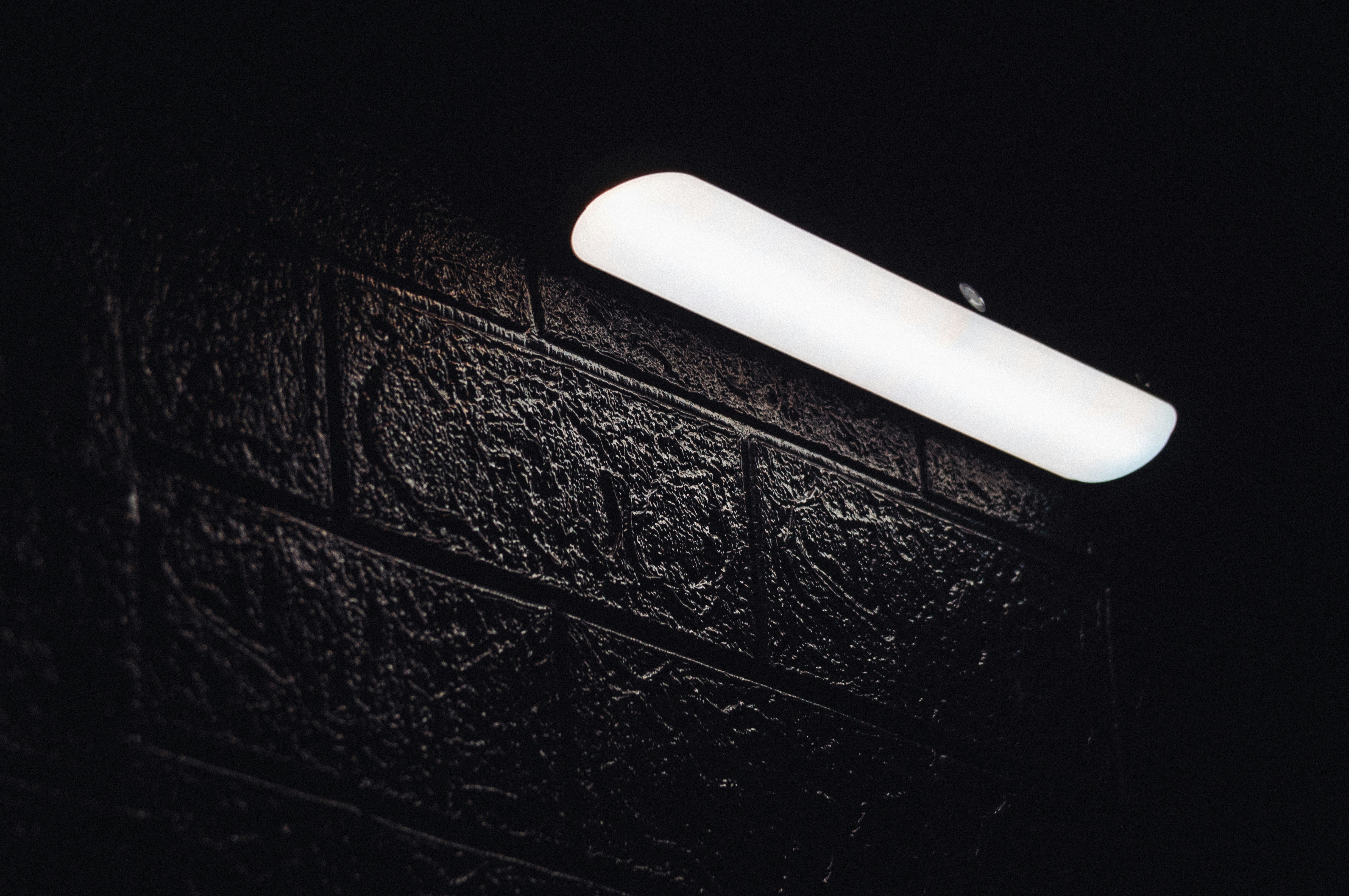 Diagonally Lit Tube on a Weathered Brick Wall
