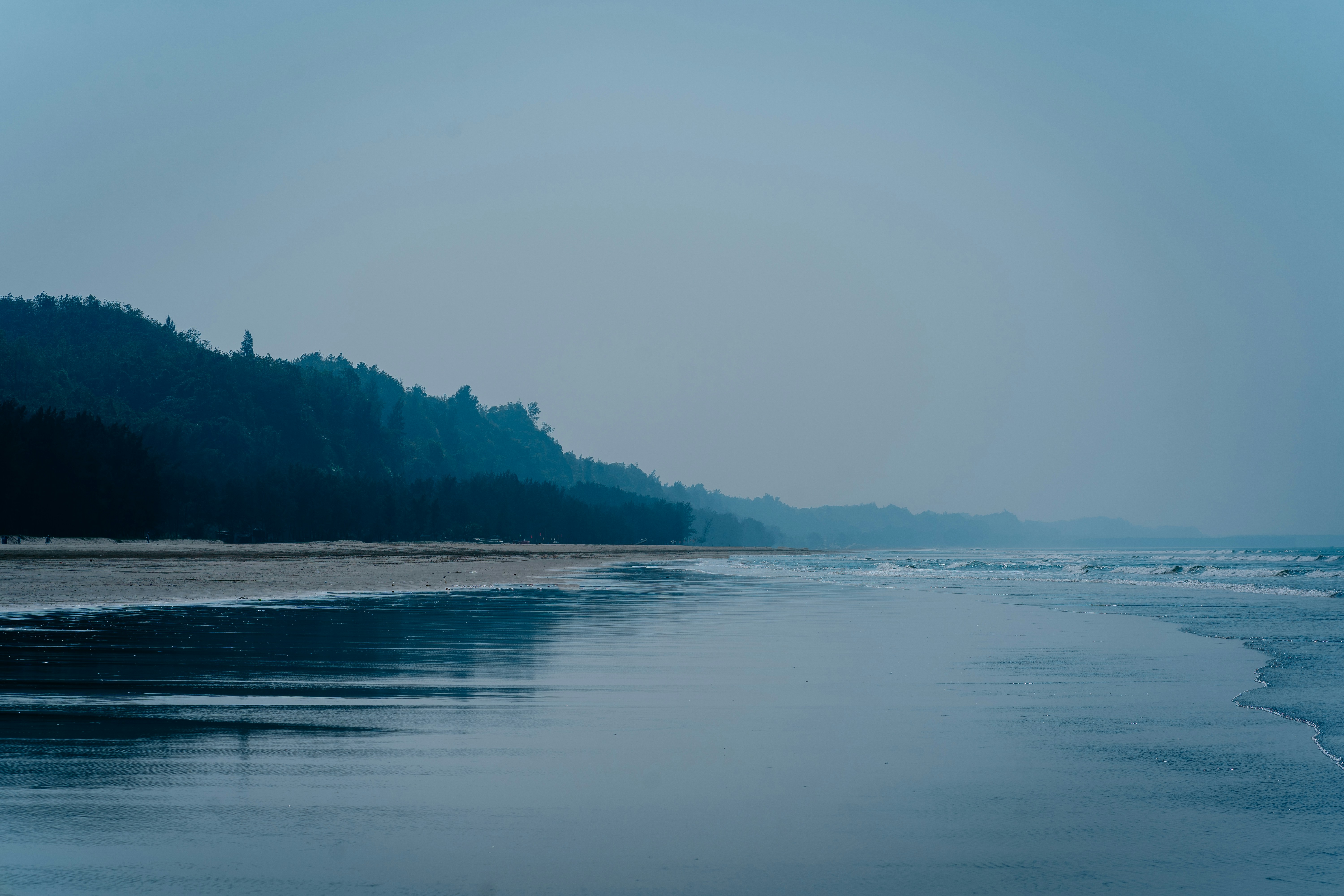 A calm beach scene with foggy skies. photo – Free Beach Image on Unsplash