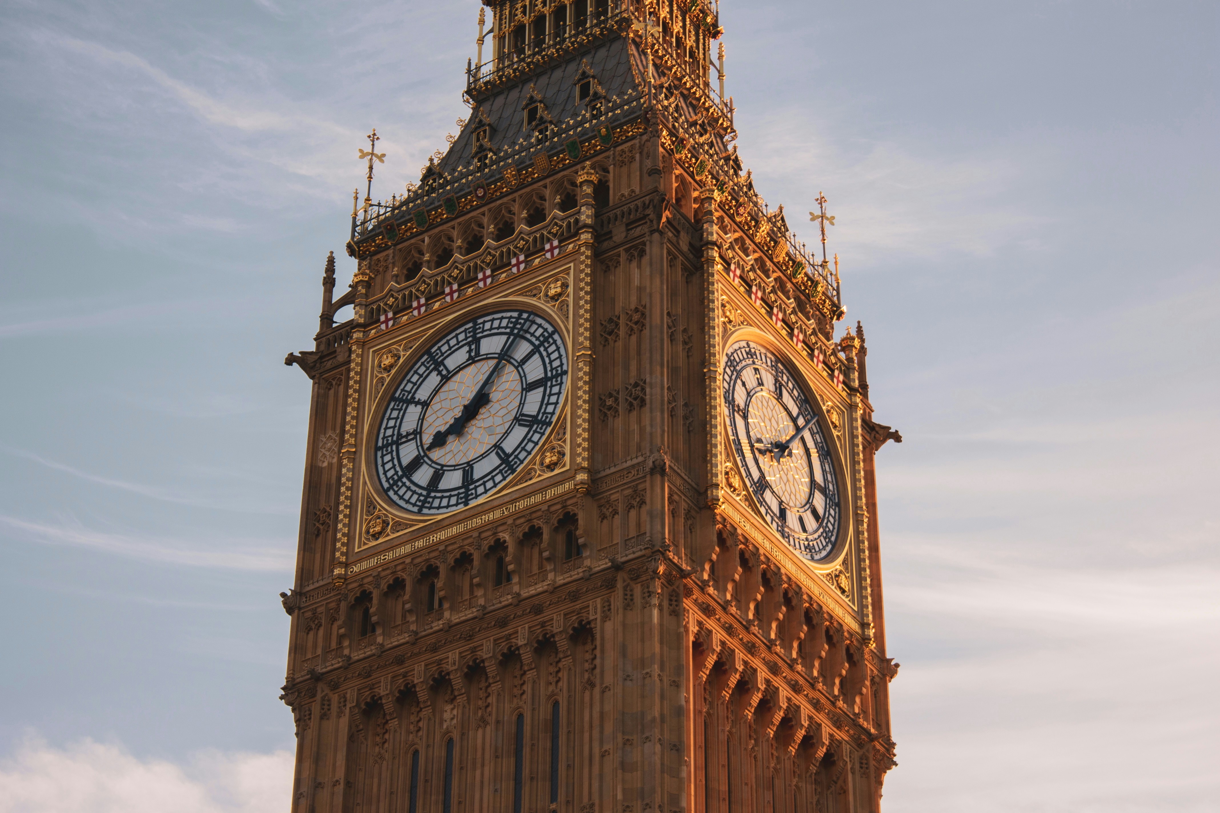 Iconic clock tower showcasing intricate architecture against a soft blue sky.