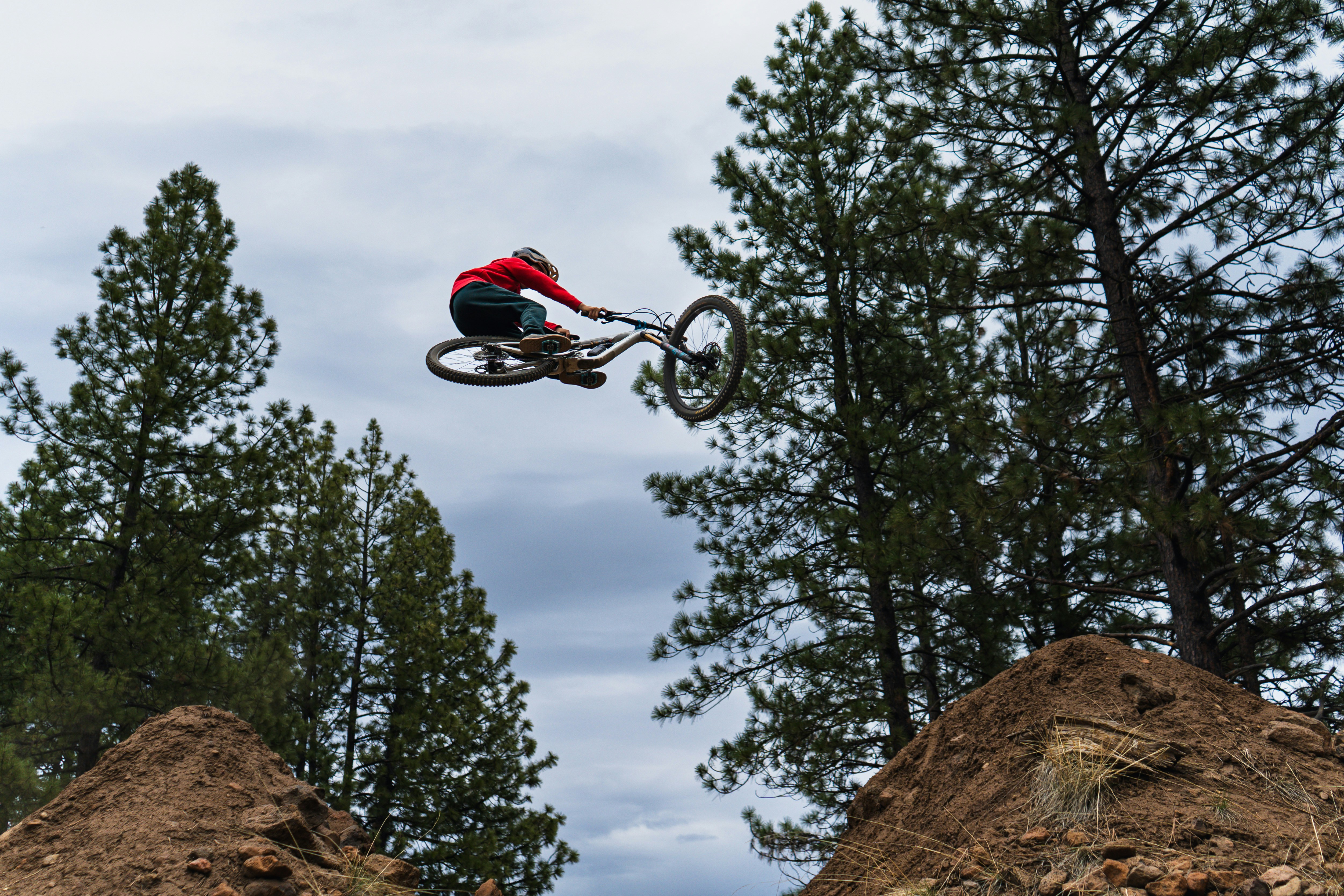 Mountain biker soaring through the air over a jump. photo – Free ...
