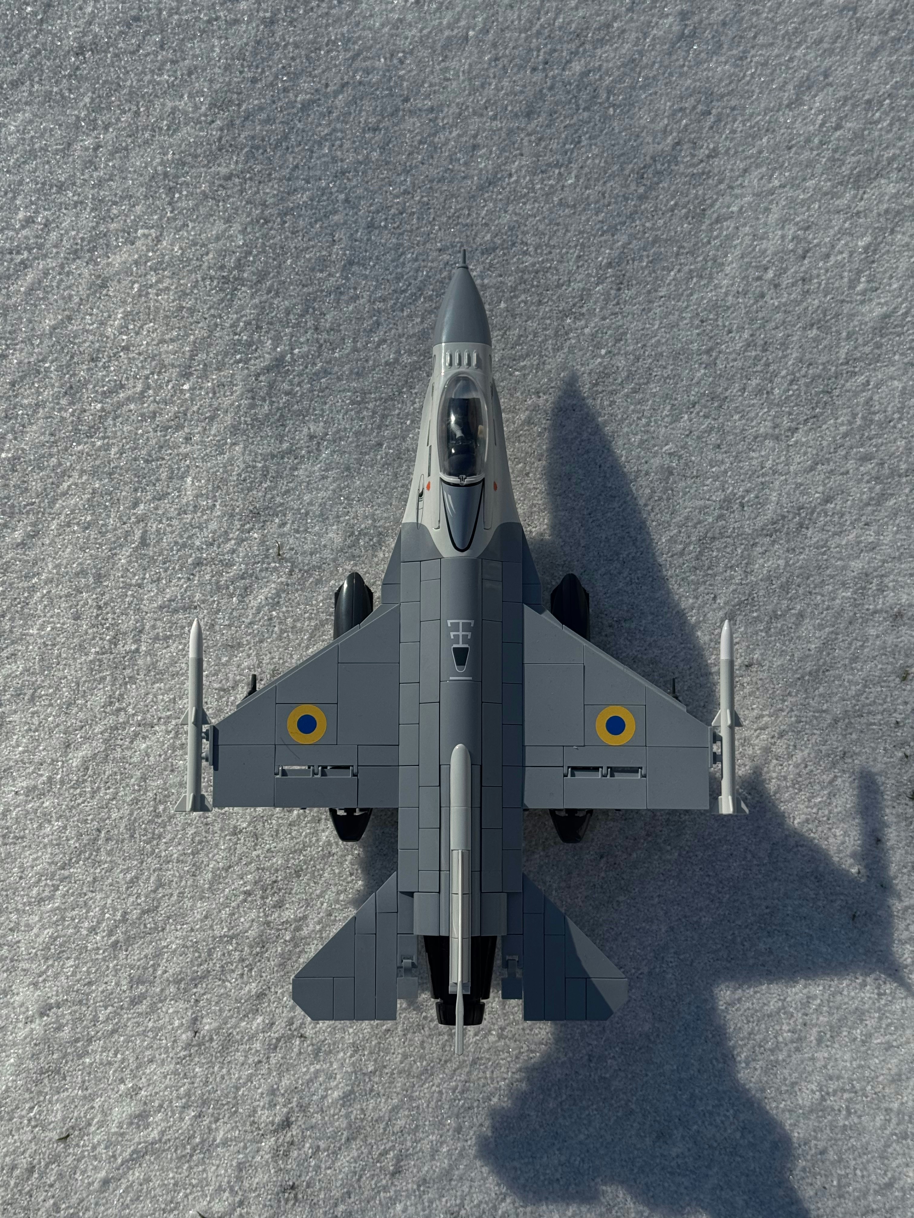 A miniature fighter jet sits on a surface. photo – Free Airplane Image ...