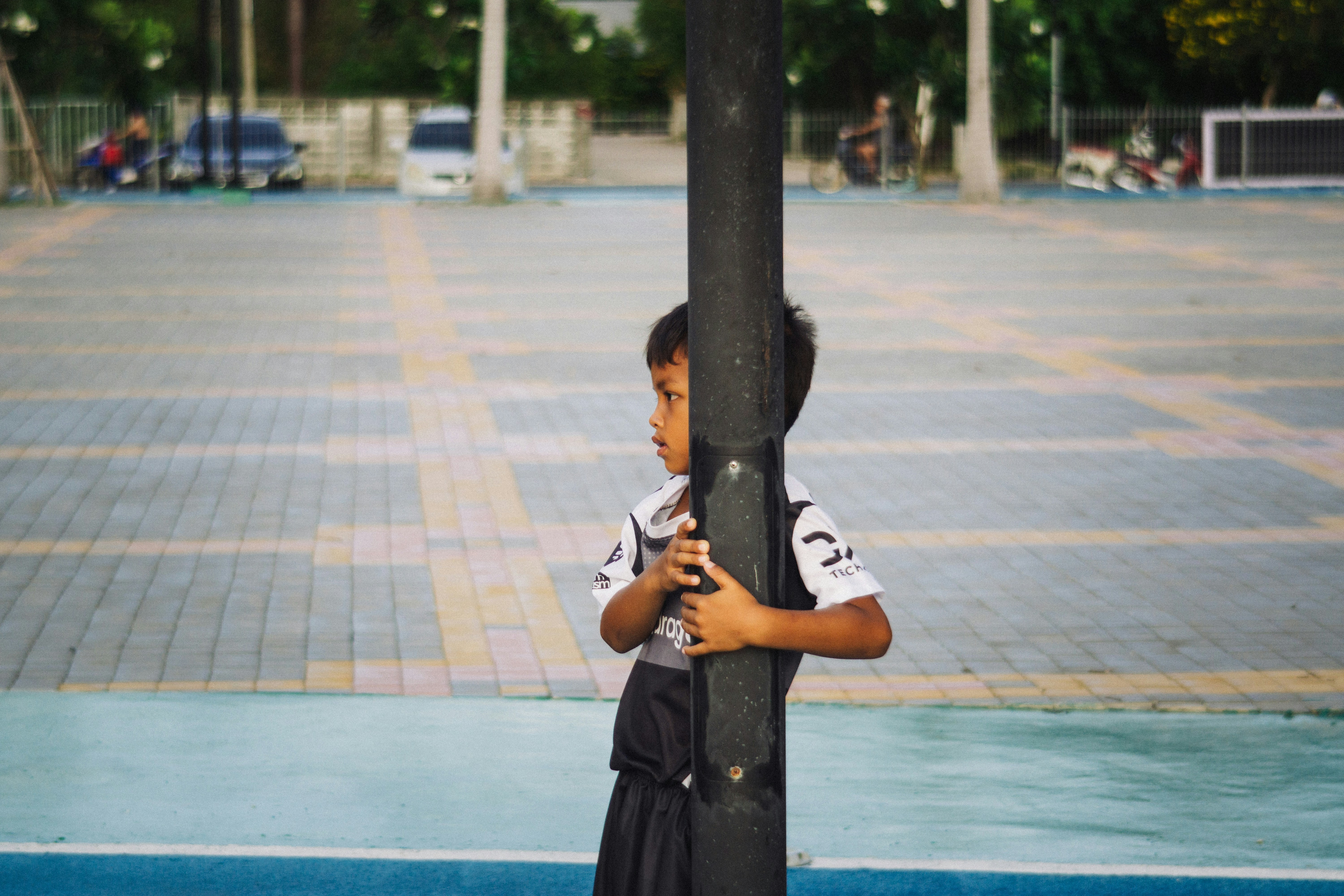 A boy hugs a pole, looking away. photo – Free Car Image on Unsplash