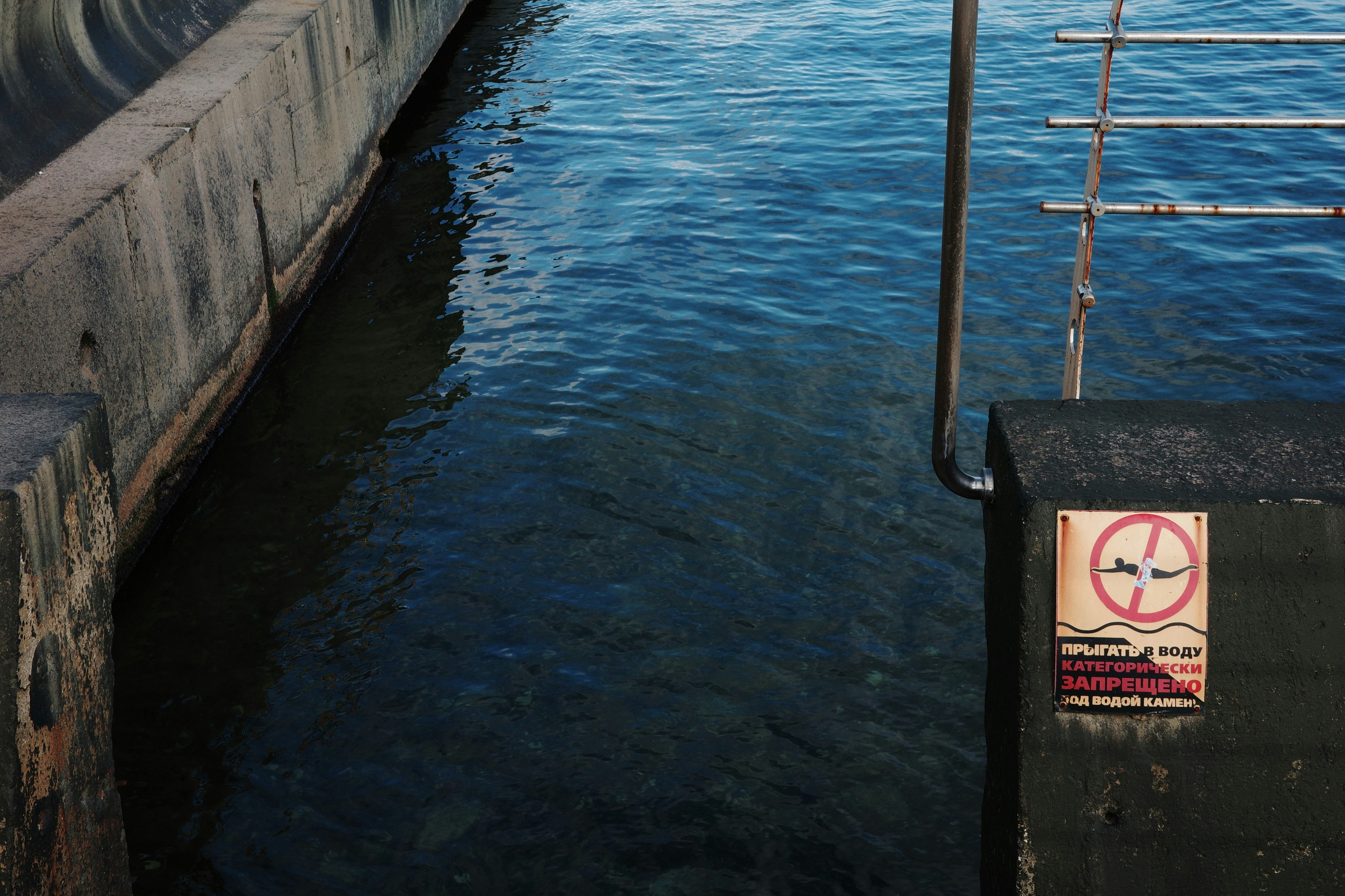 Water and a warning sign on a concrete structure. photo – Free Sea ...