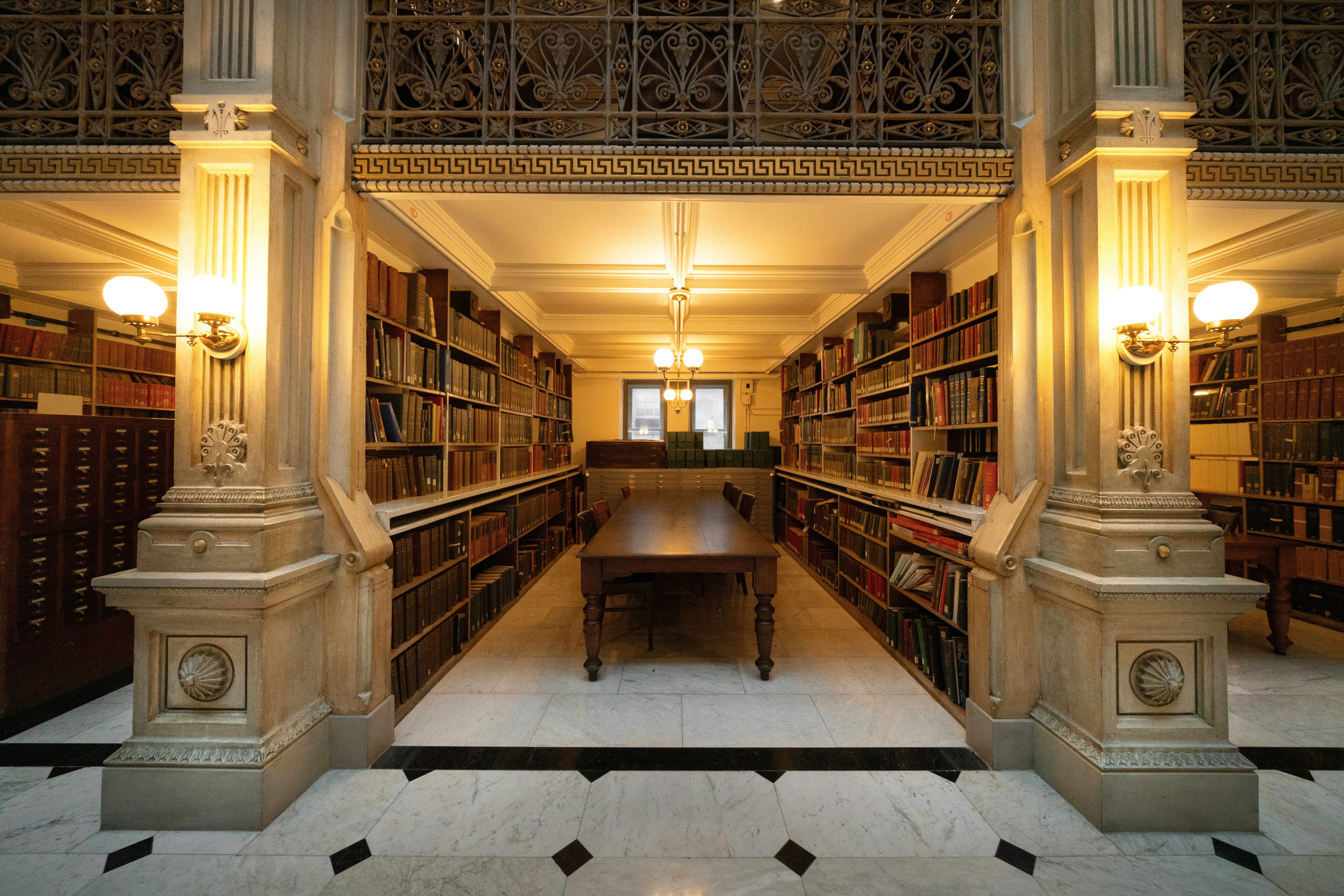 A library with books, tables, and pillars. photo – Free Architecture ...