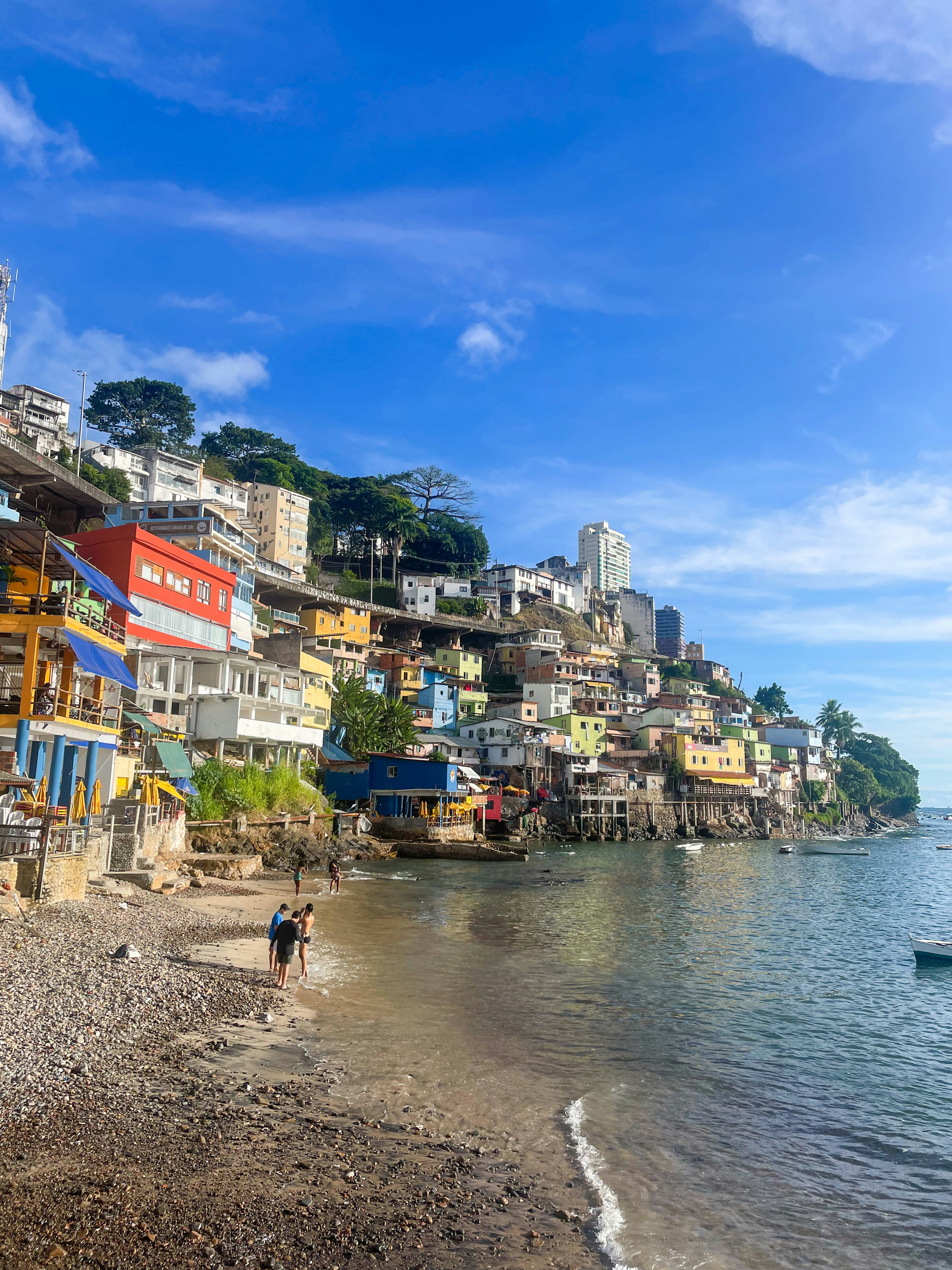 Colorful hillside harbor village along sunlit shoreline