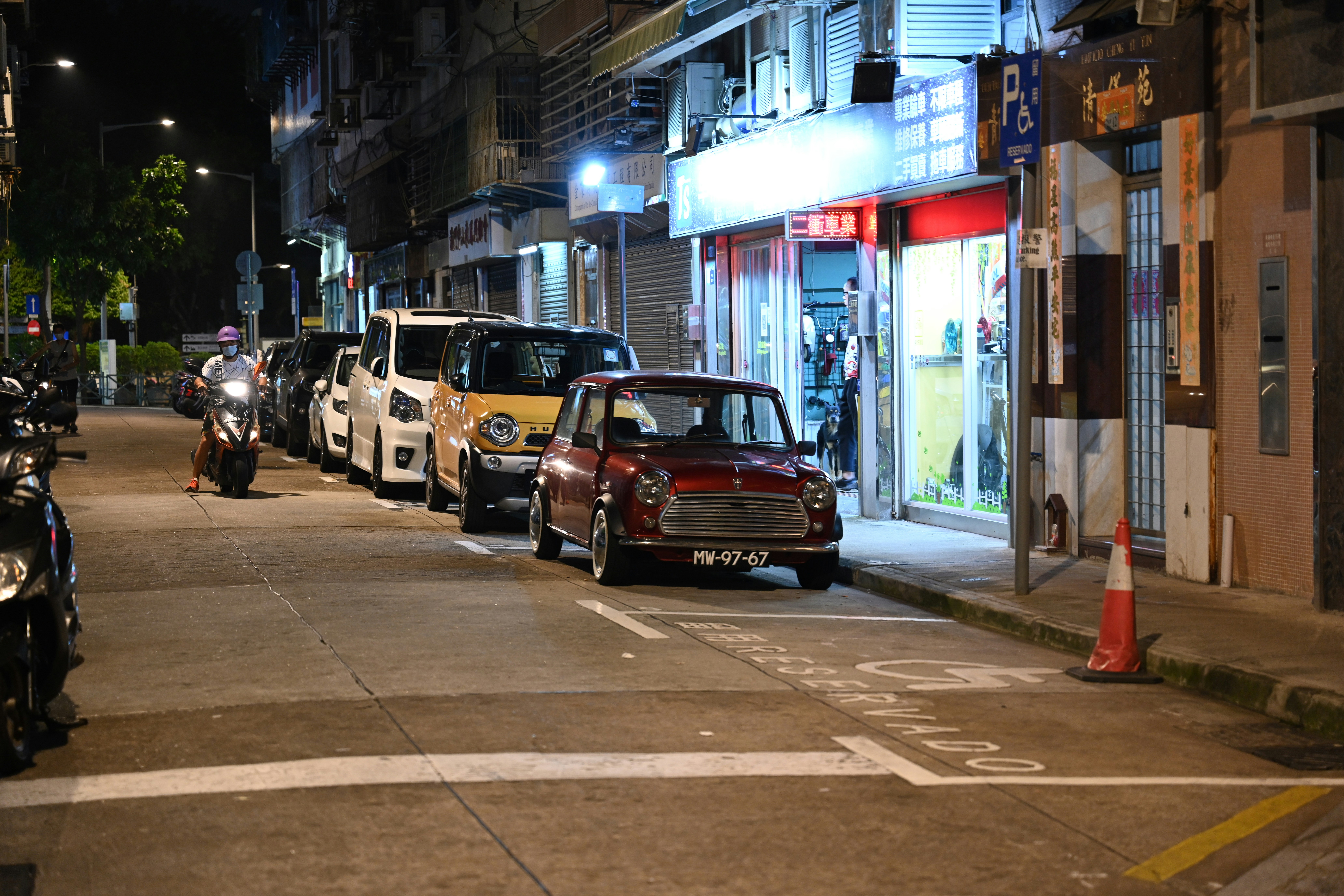Cars are parked on a city street at night.