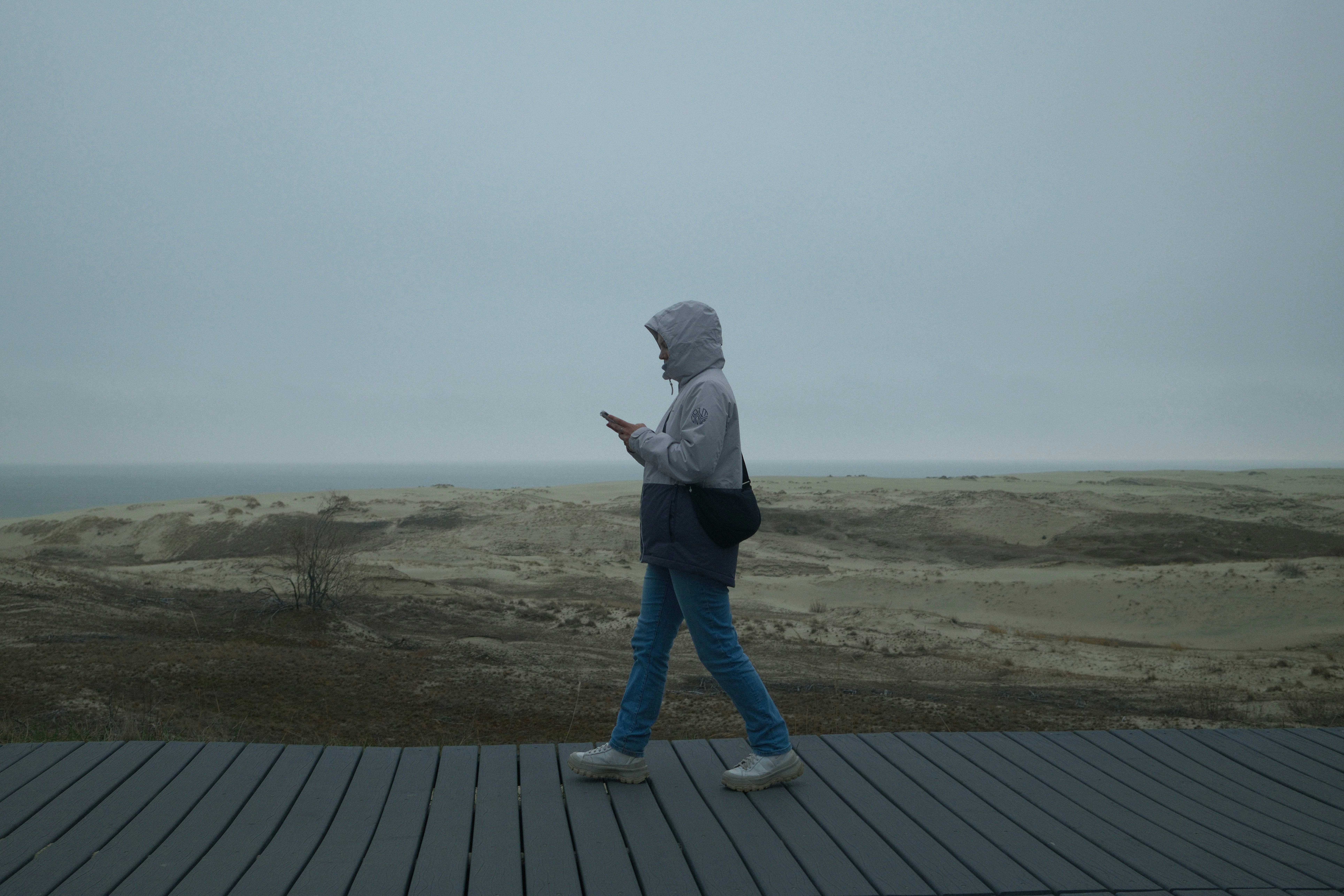 Solitary Stride Along a Wind-Washed Coastal Boardwalk