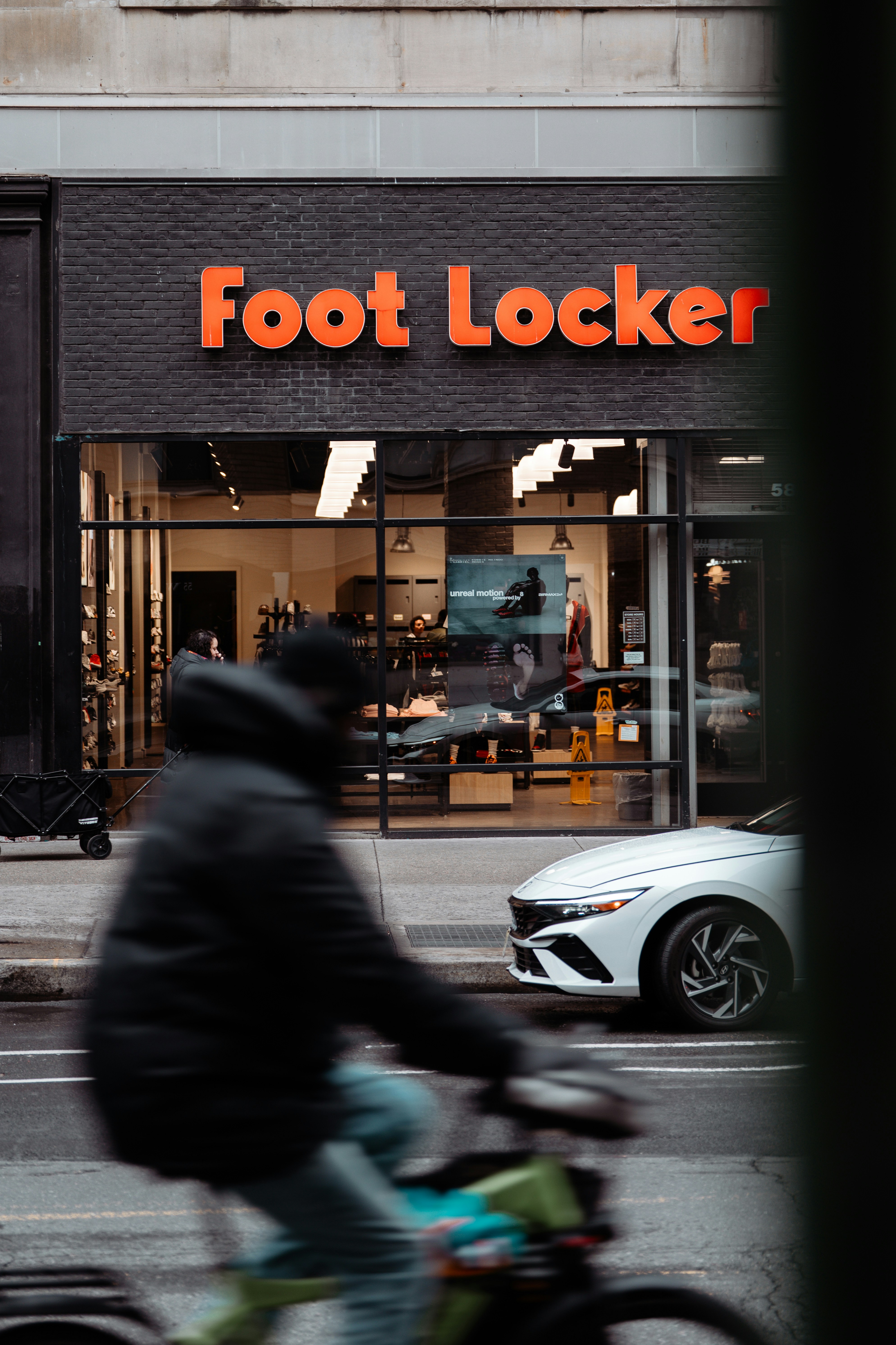 Foot Locker Framed by a Blurred City Pulse