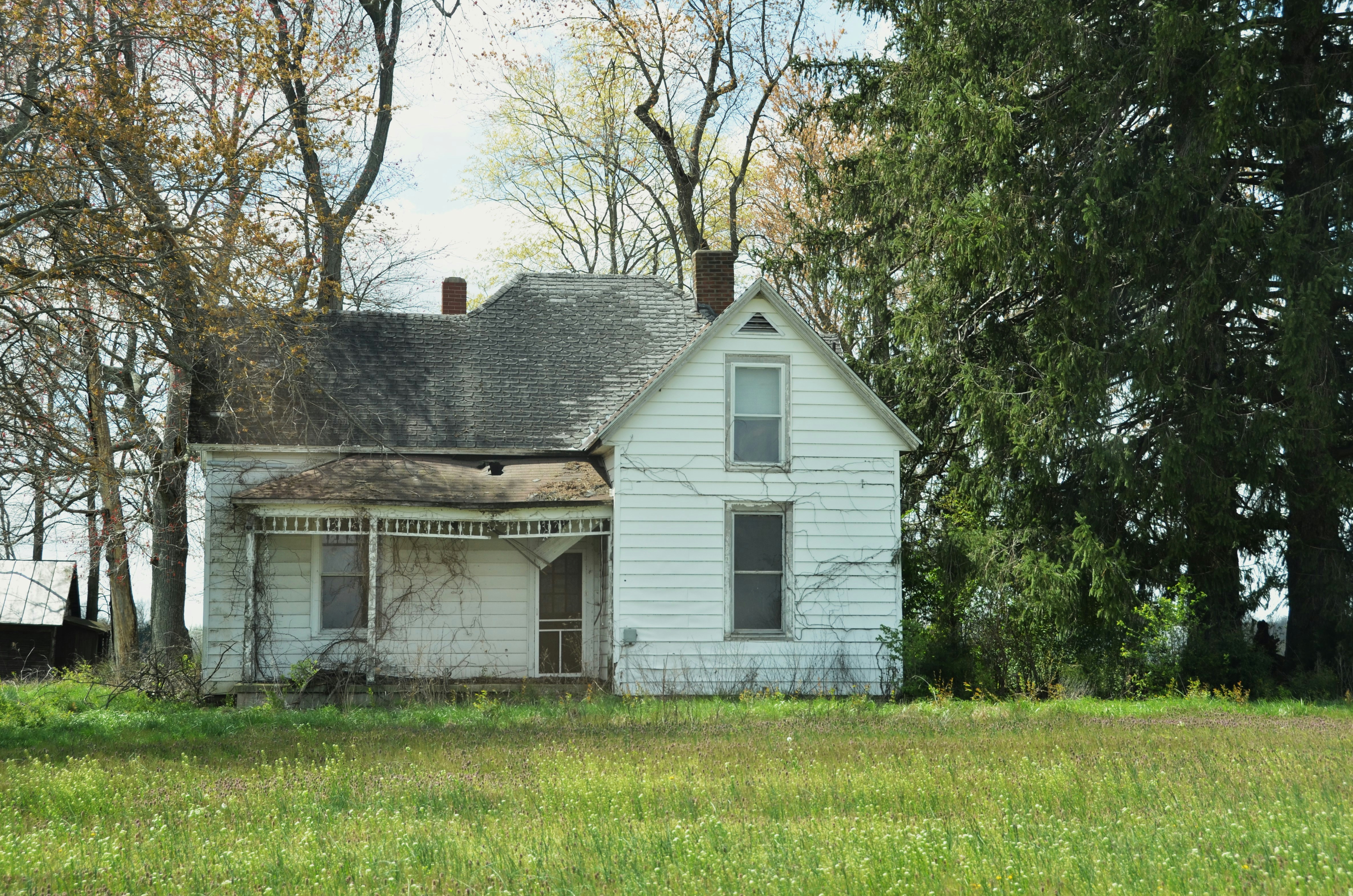 An old, weathered house sits in a field. photo – Free House Image on Unsplash