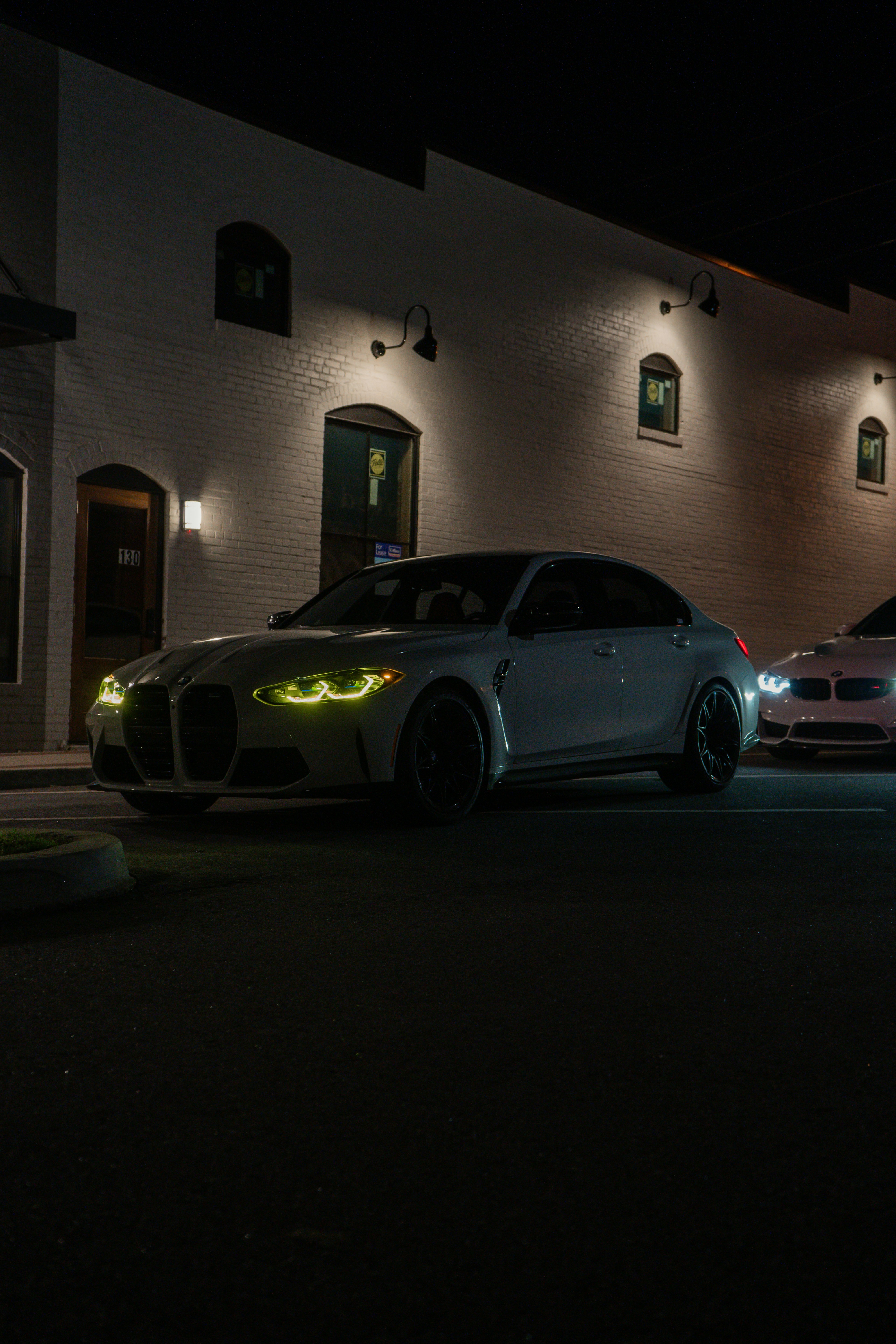 Two bmws are parked in front of a building at night. photo – Free Car ...