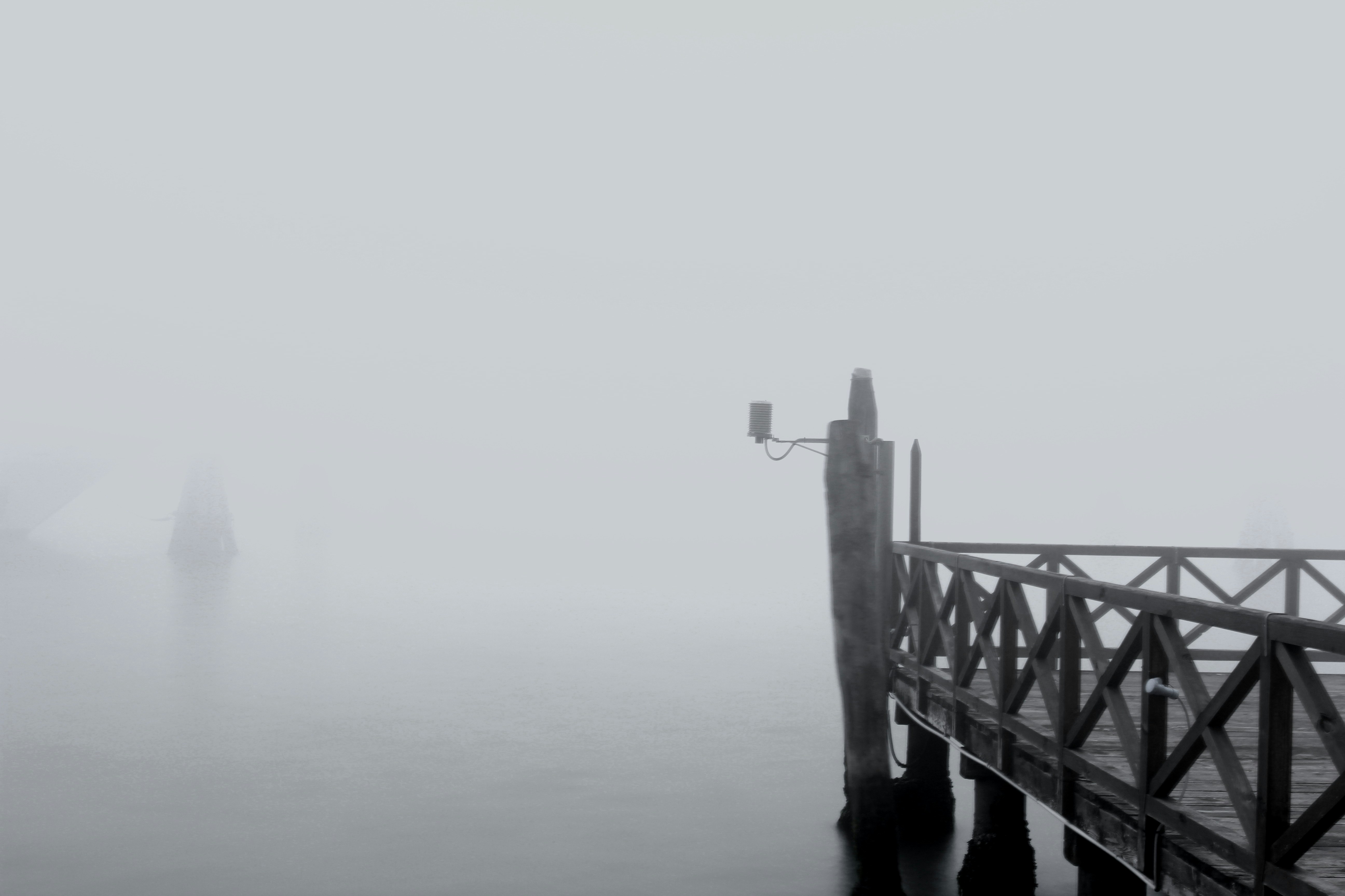 Lantern at the Edge: A Wooden Pier Breaches the Fog