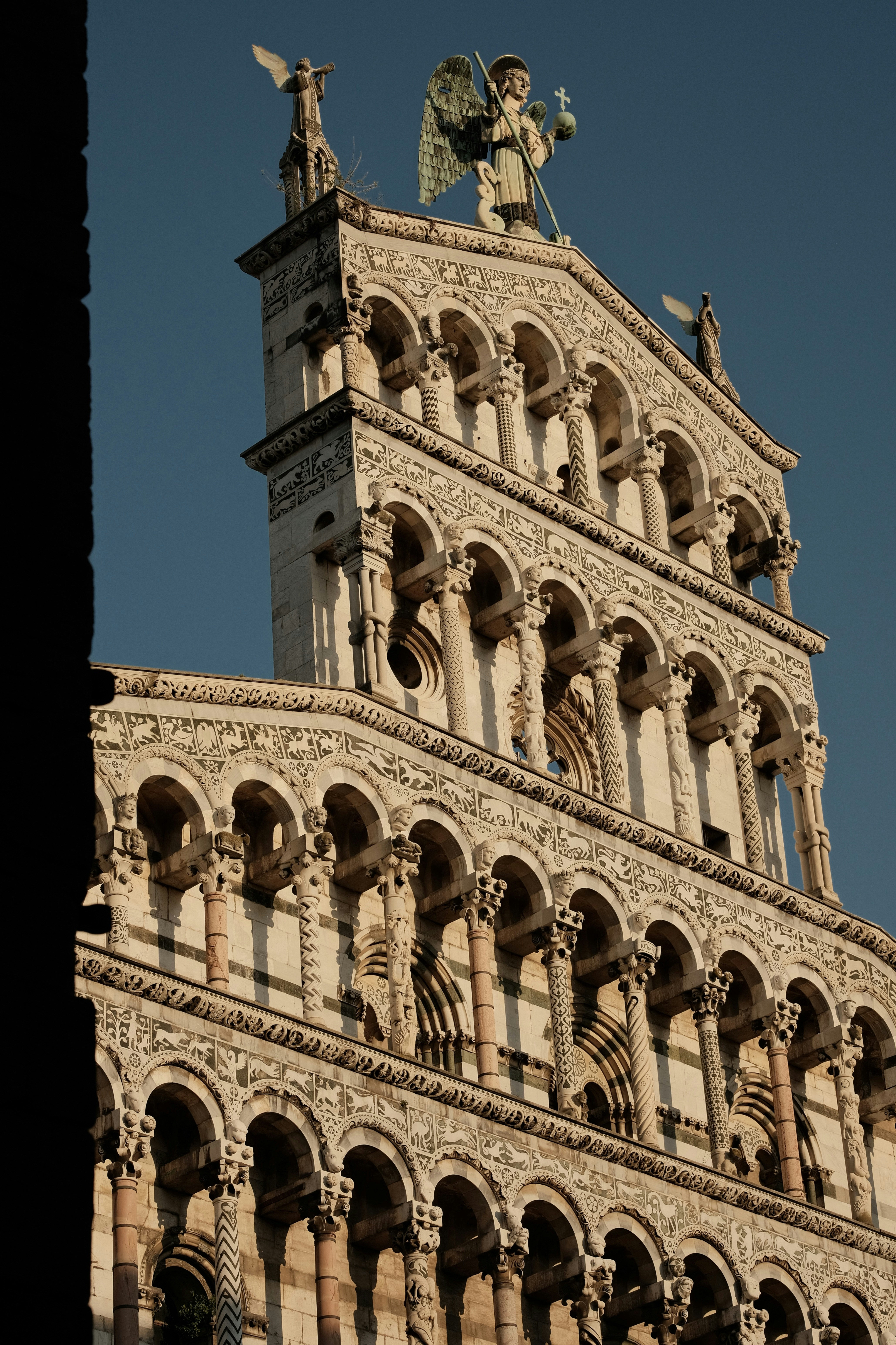 Angel Over the Arches: Sunlit Tiered Stone Facade
