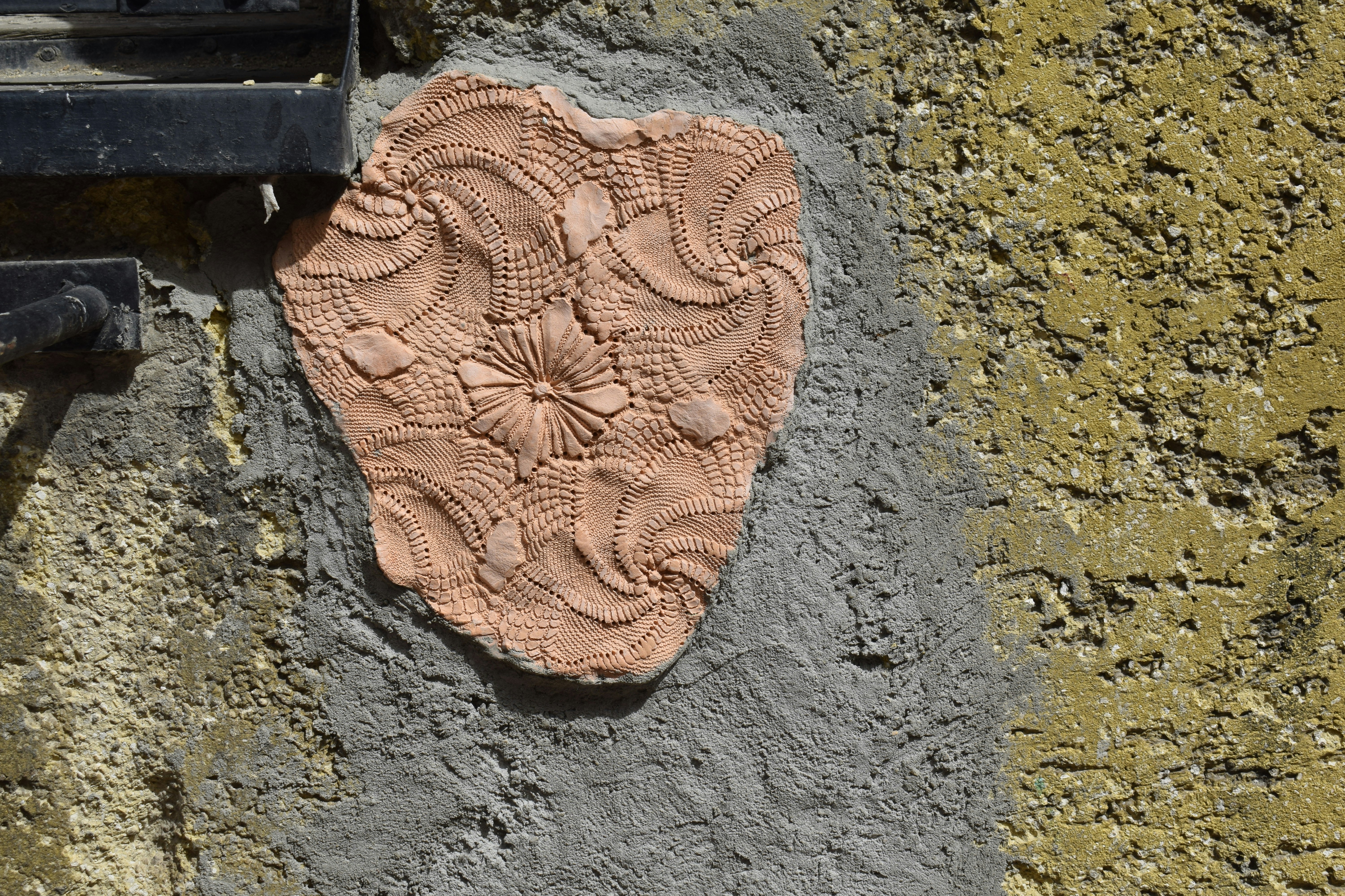 A Patina of Texture: The Pink Heart Embedded in a Weathered Wall