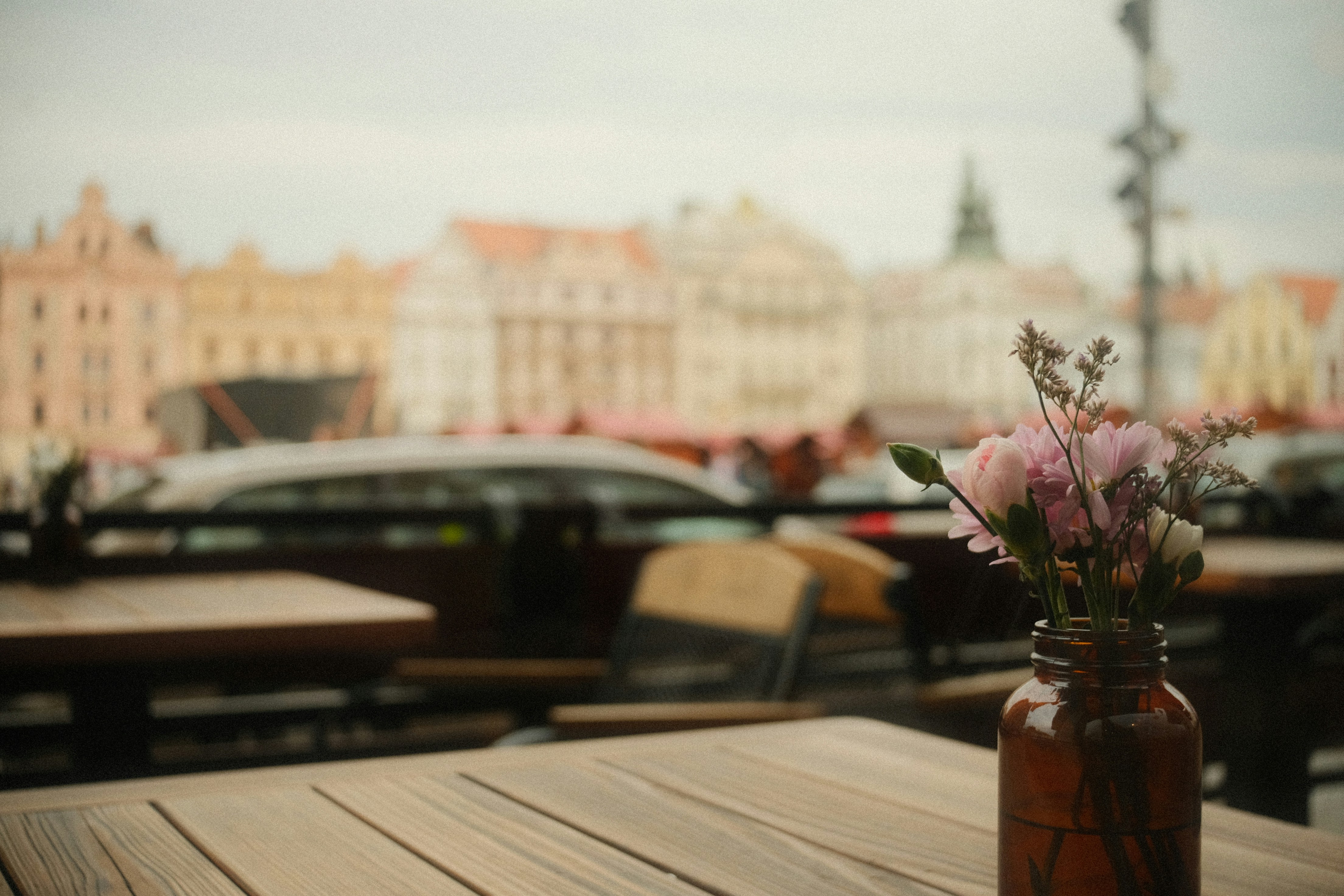 Amber Bottle Bouquet on a Riverside Table with a Softly Blurred Cityscape