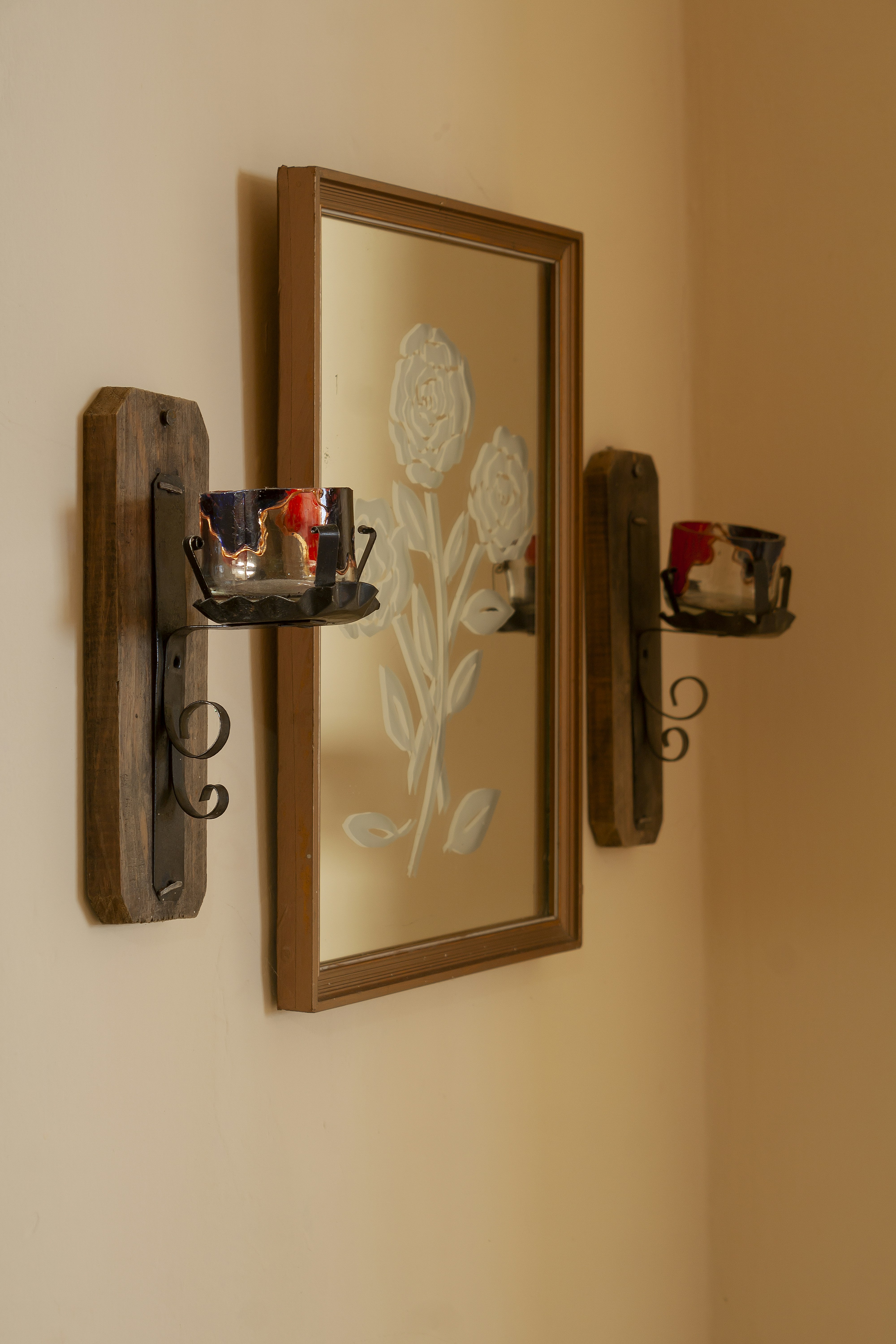 Amber-lit Mirror with Etched Floral Panel, Flanked by Rustic Sconces