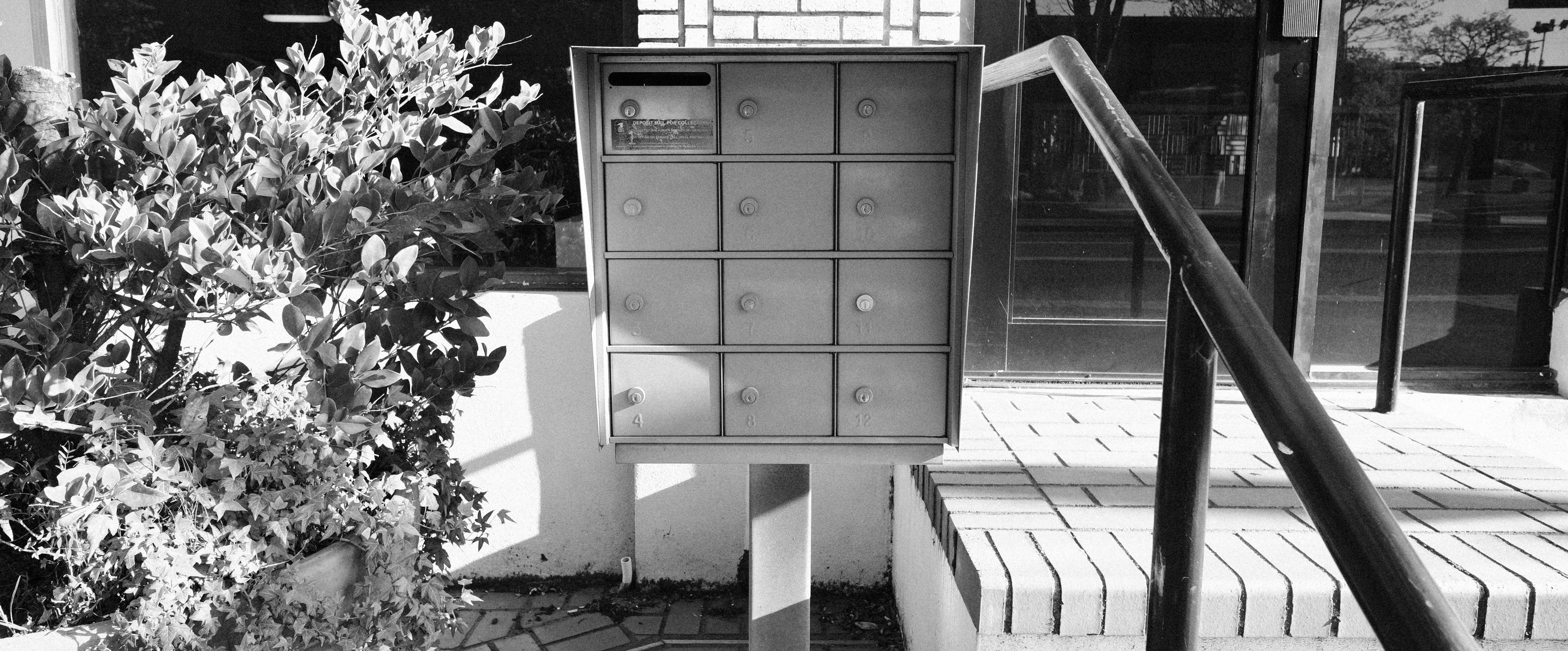 Monochrome Mailbox at the Threshold of Steps and Shadow