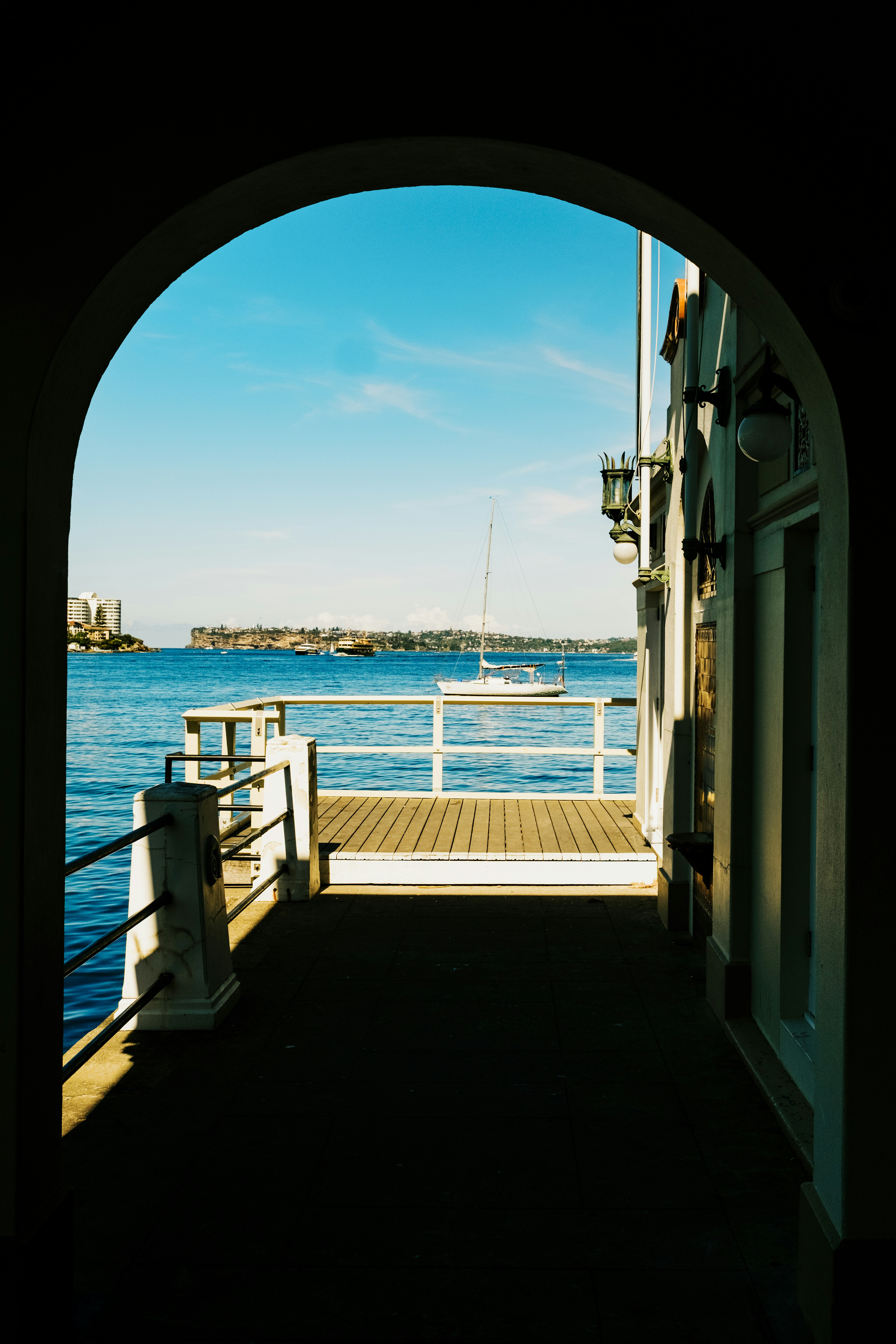 Threshold to the Blue: A Sunlit Harbor Through an Archway