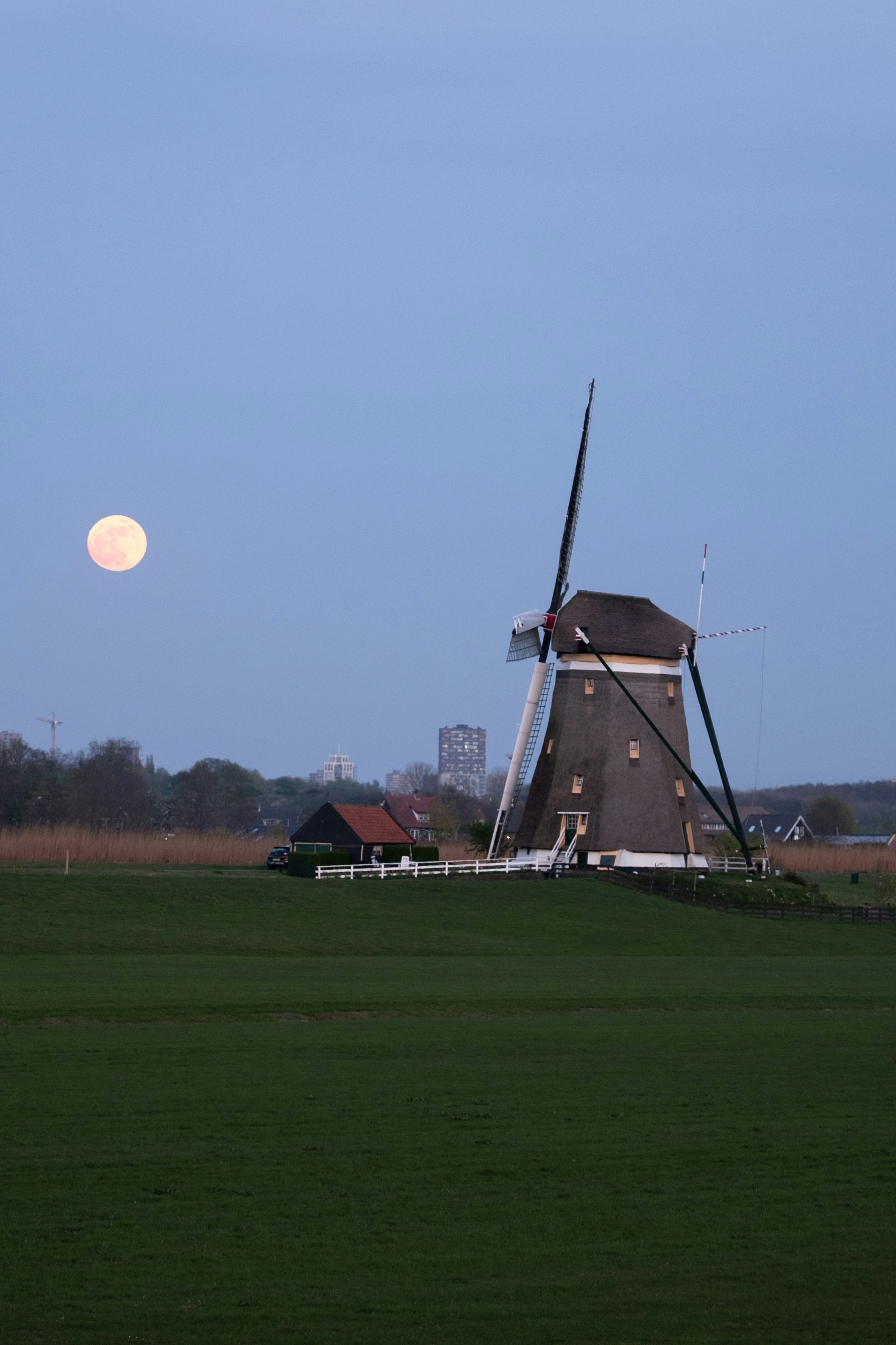 A moon shines over a windmill at dusk. photo – Free Sunset Image on ...