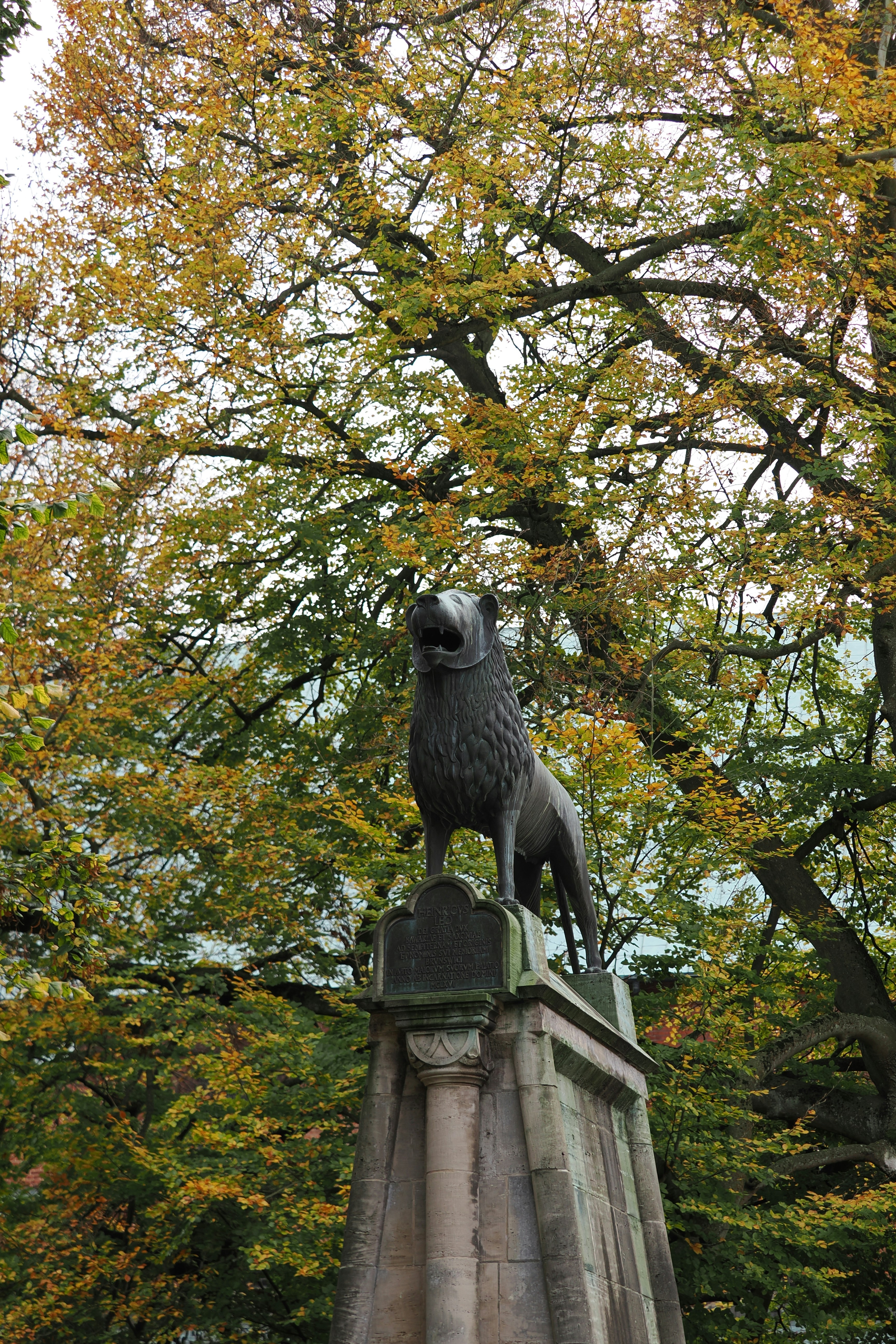 Autumn Sentinel: Wolf Statue Standing Guard on a Stone Pedestal