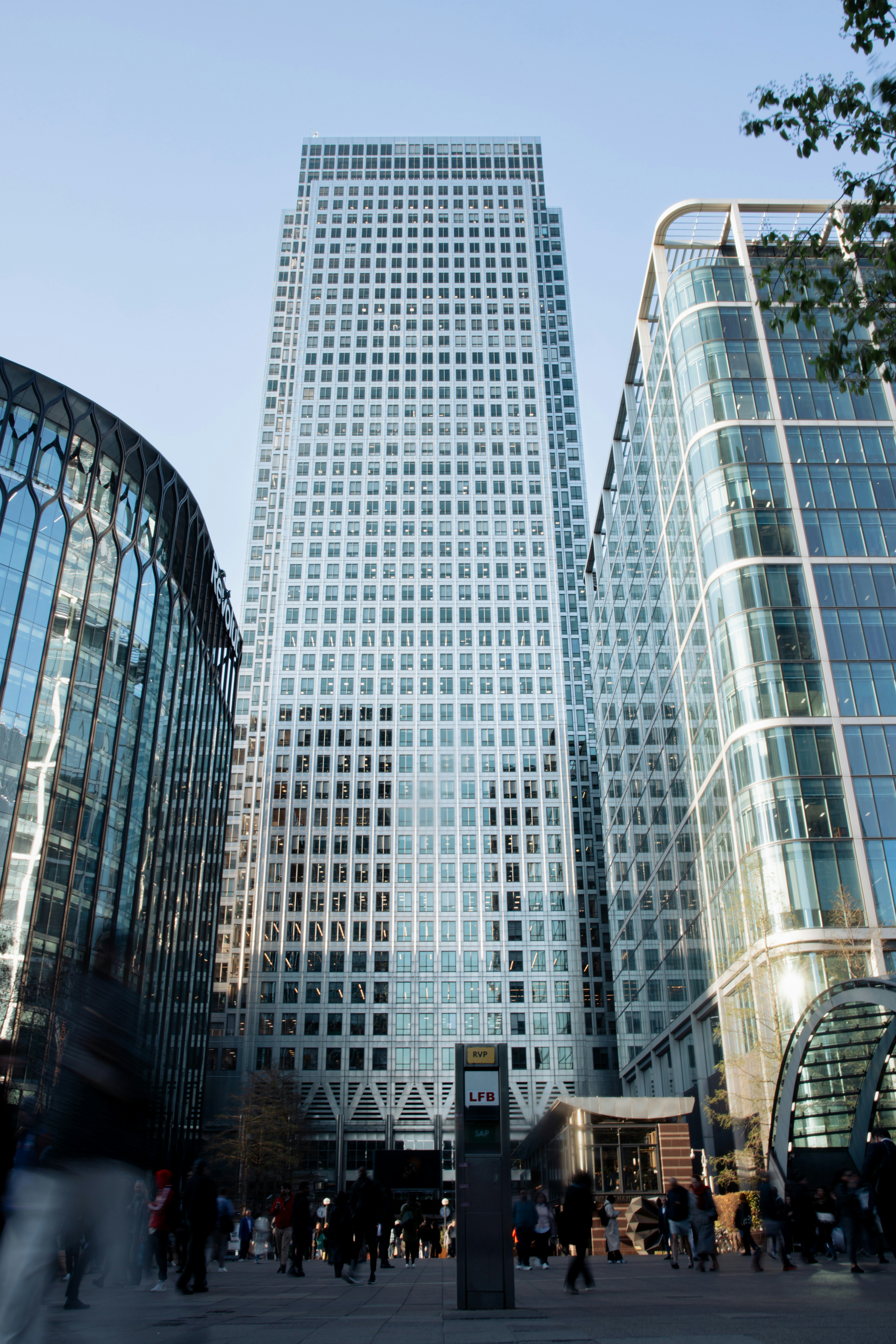 Tall skyscraper towers over the surrounding buildings. photo – Free ...