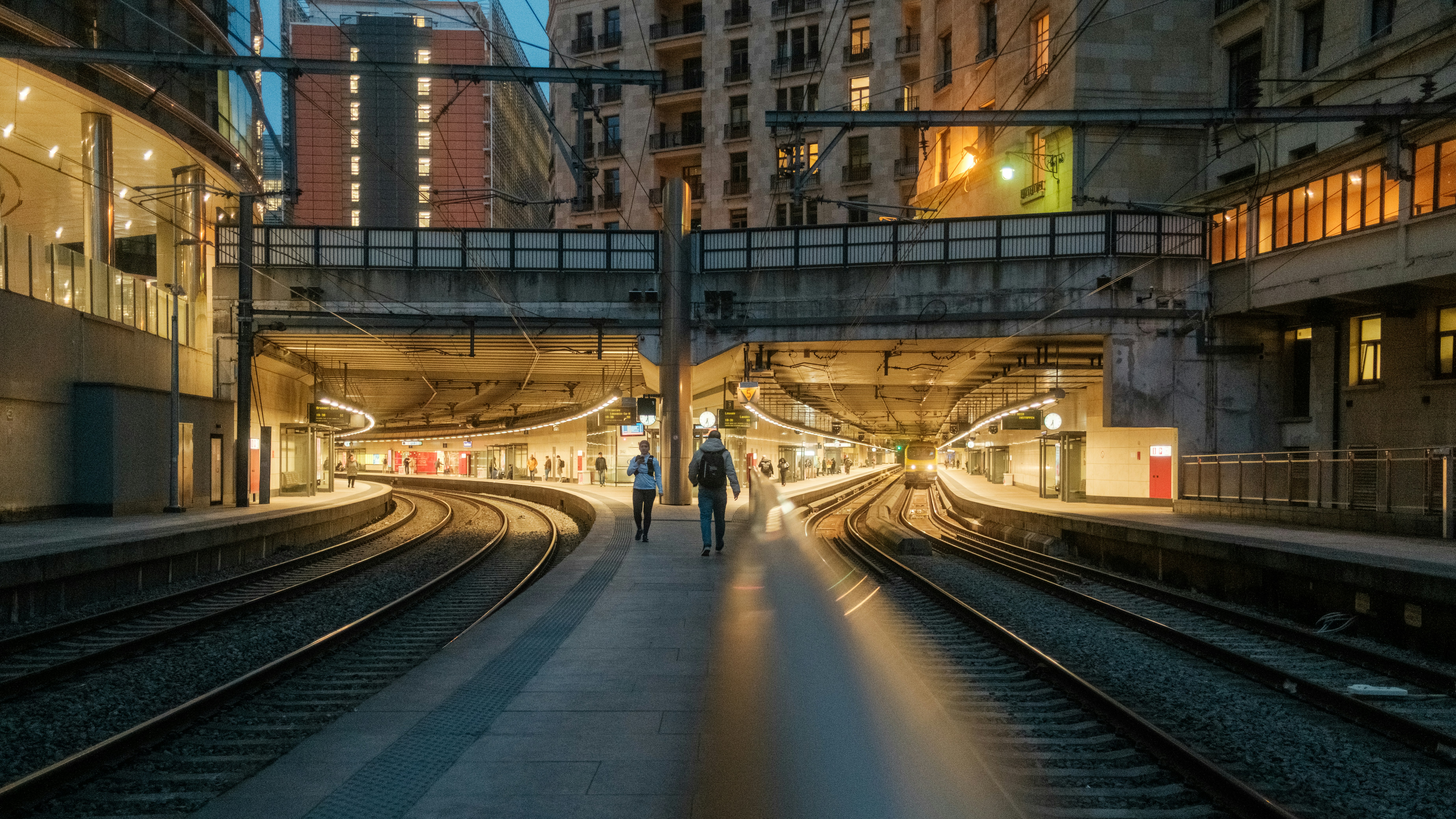 People walk on a train platform at dusk. photo – Free City Image on ...