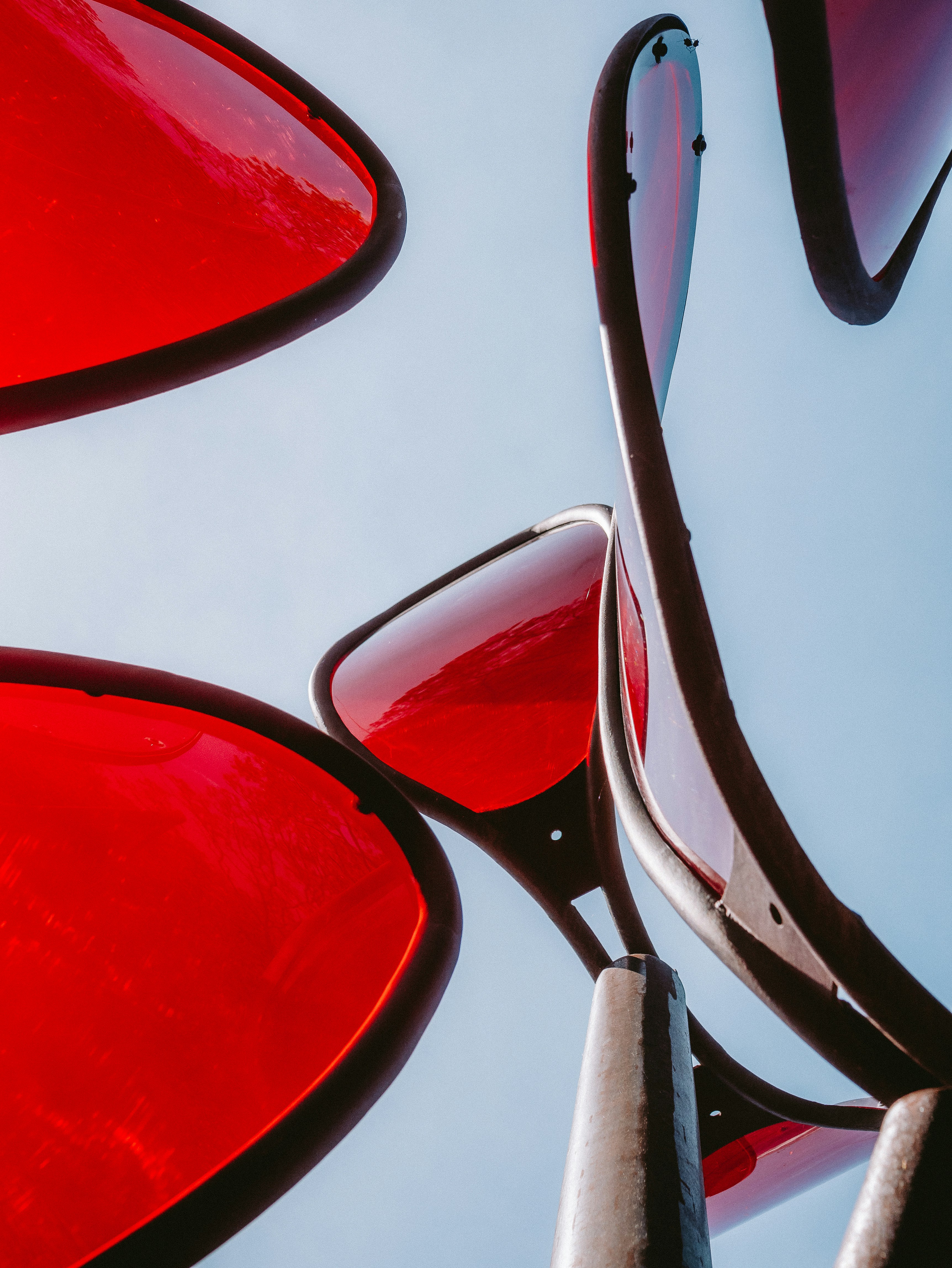 Crimson Reflections: Macro Close-Up of Red Sunglasses Against a Sky-Blue Backdrop