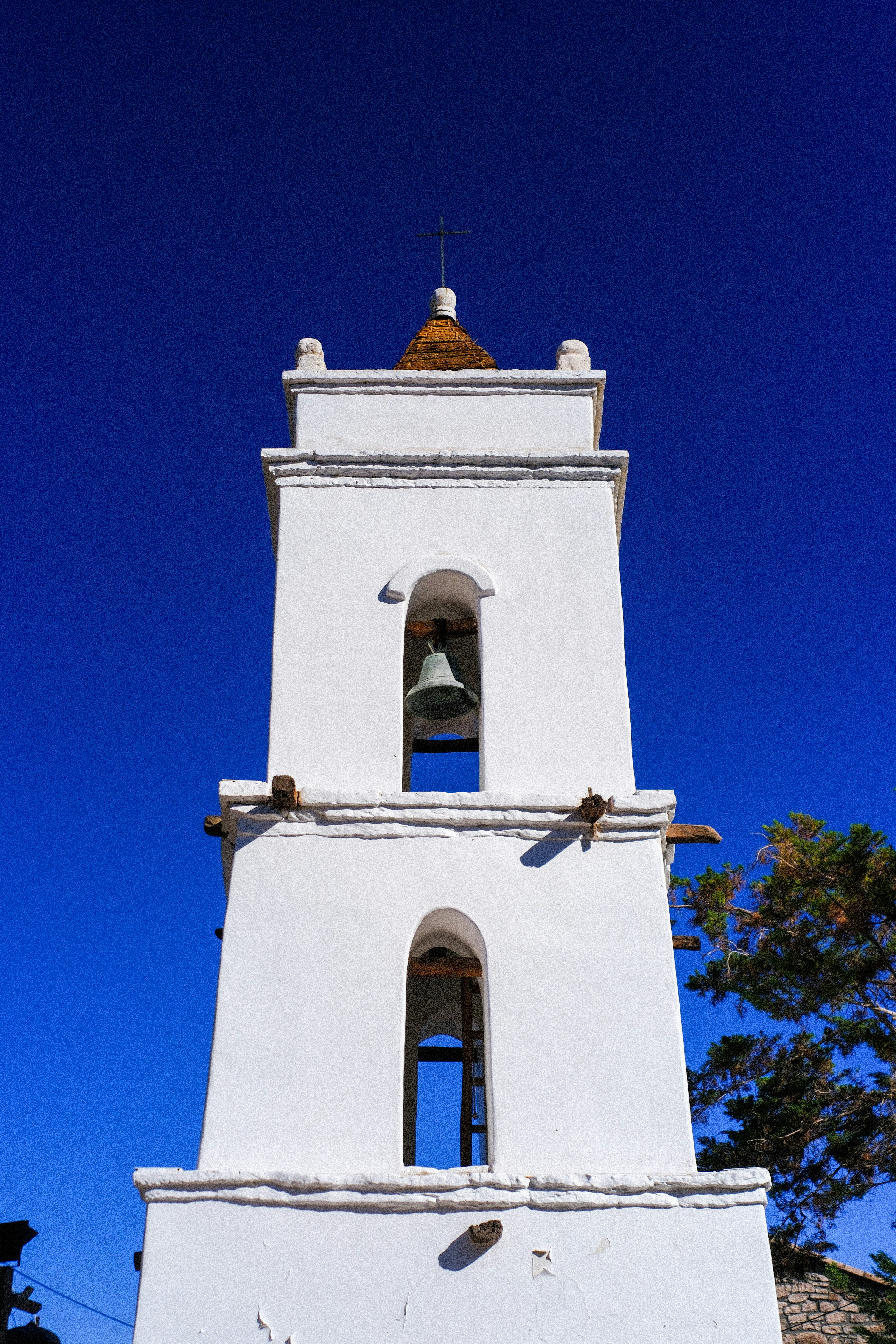 White church bell tower against a blue sky.