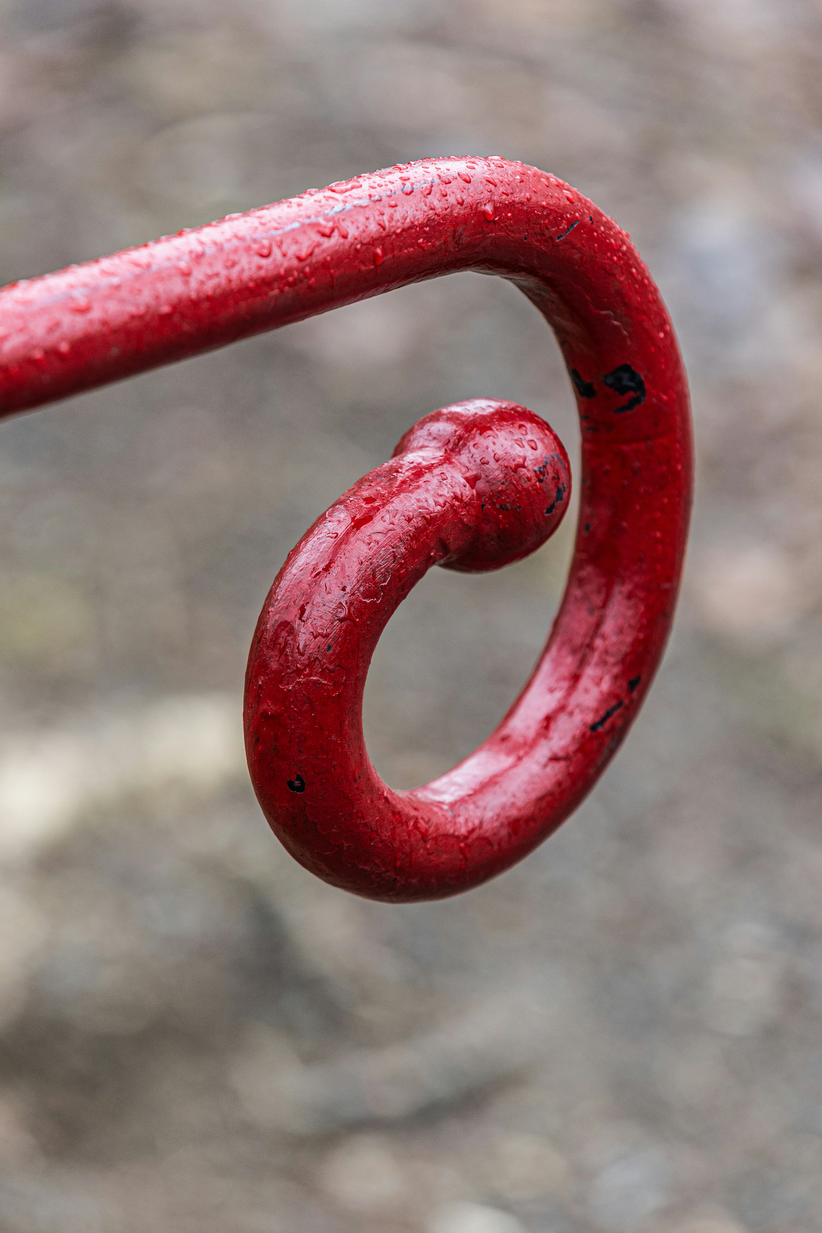 Red Bending Loop: Close-up of a Weathered Playground Bar