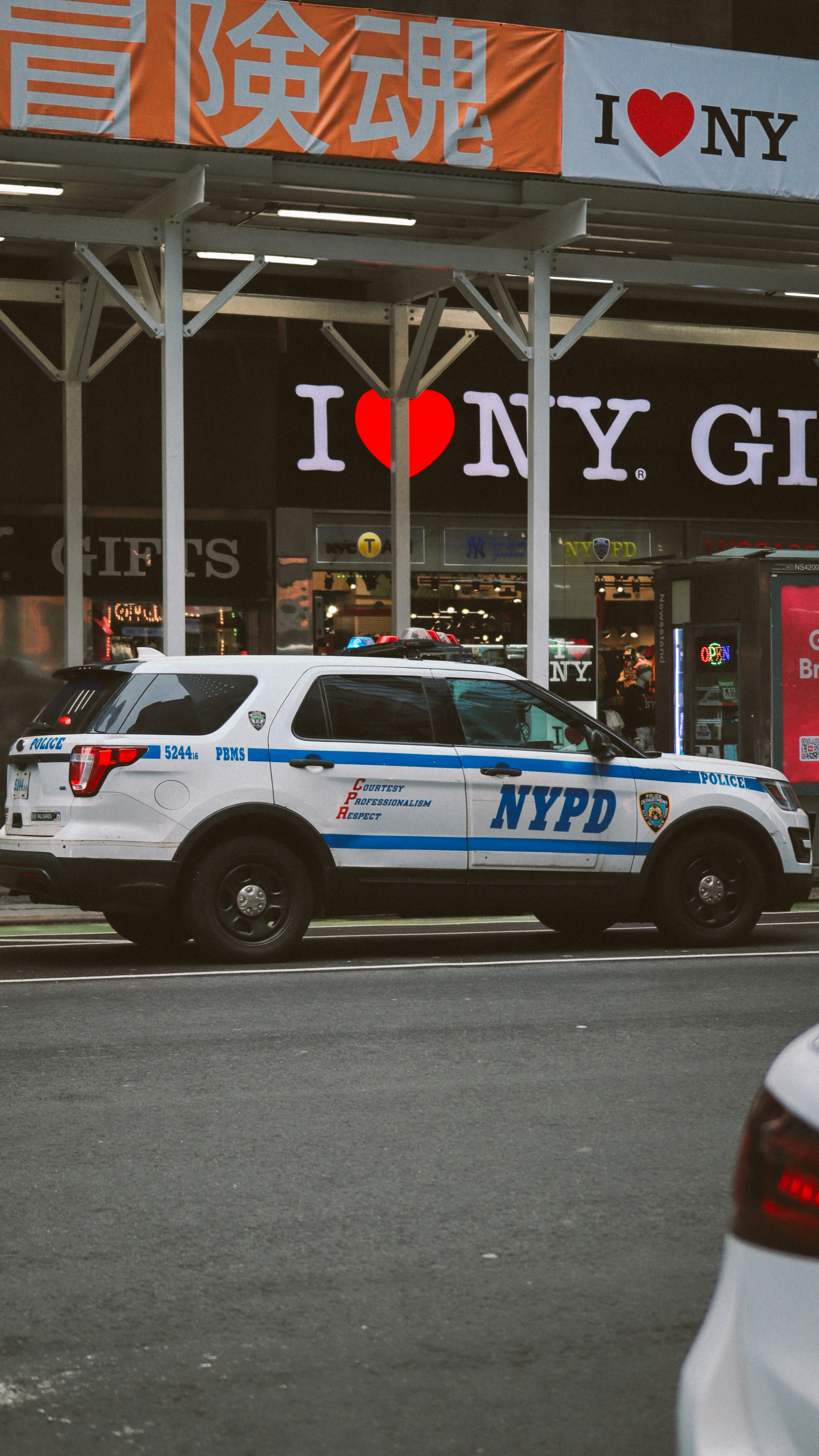 An nypd car parked in front of "i love ny" sign. photo – Free Car Image ...