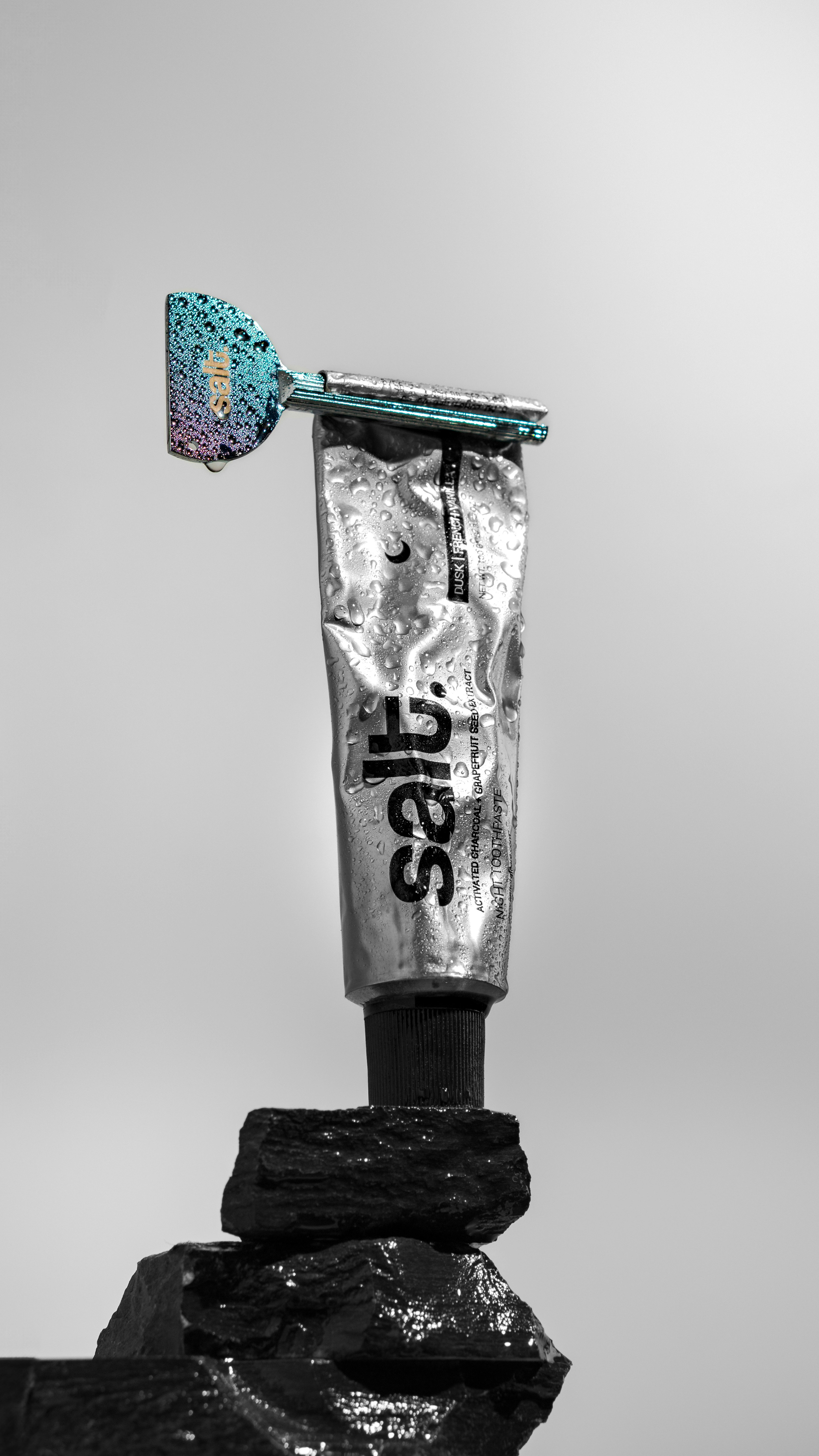 product photography of a grey bottle of toothpaste.