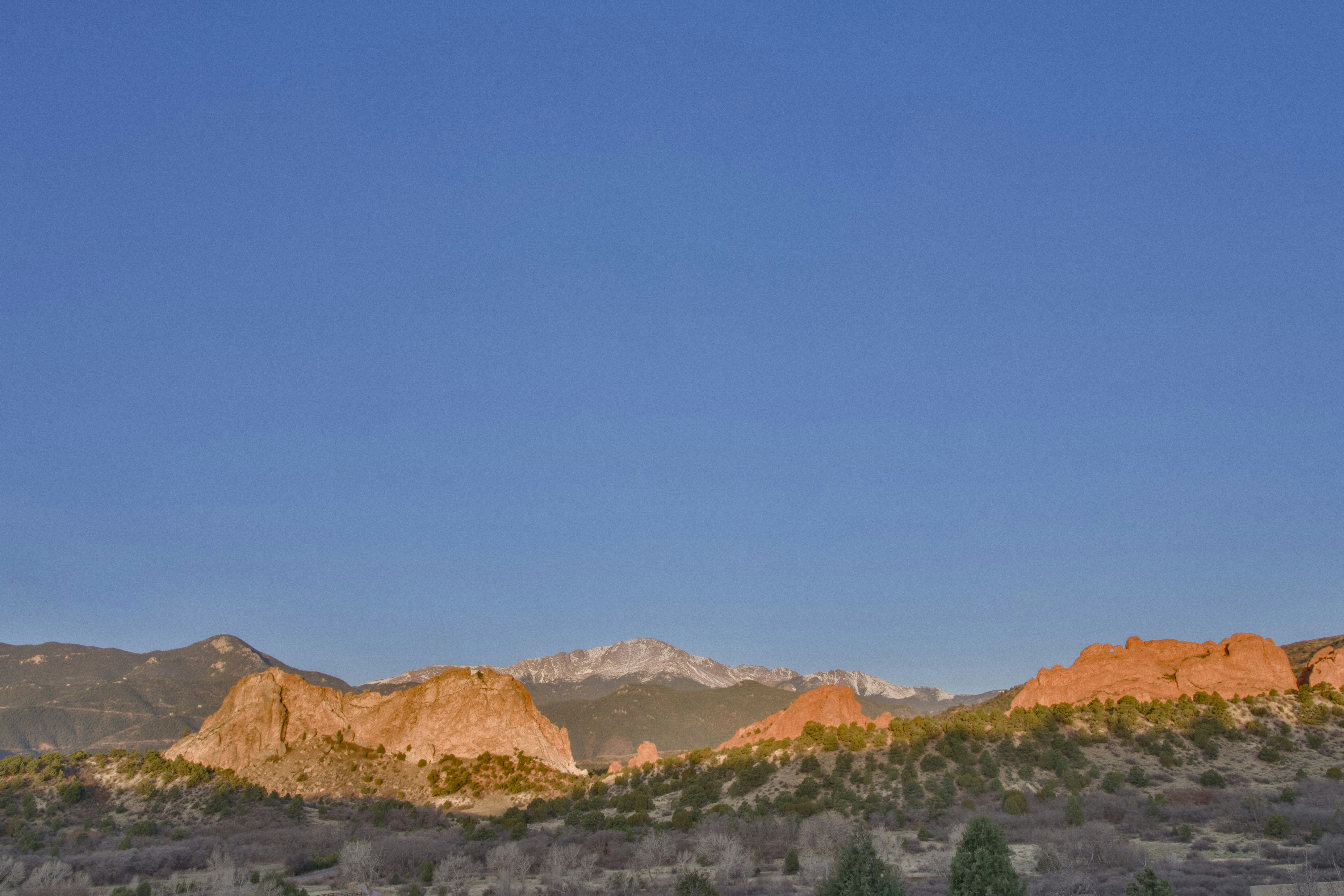 Crimson Ridge at Desert Dawn: Orange Rock Formations Beneath a Clear Blue Sky