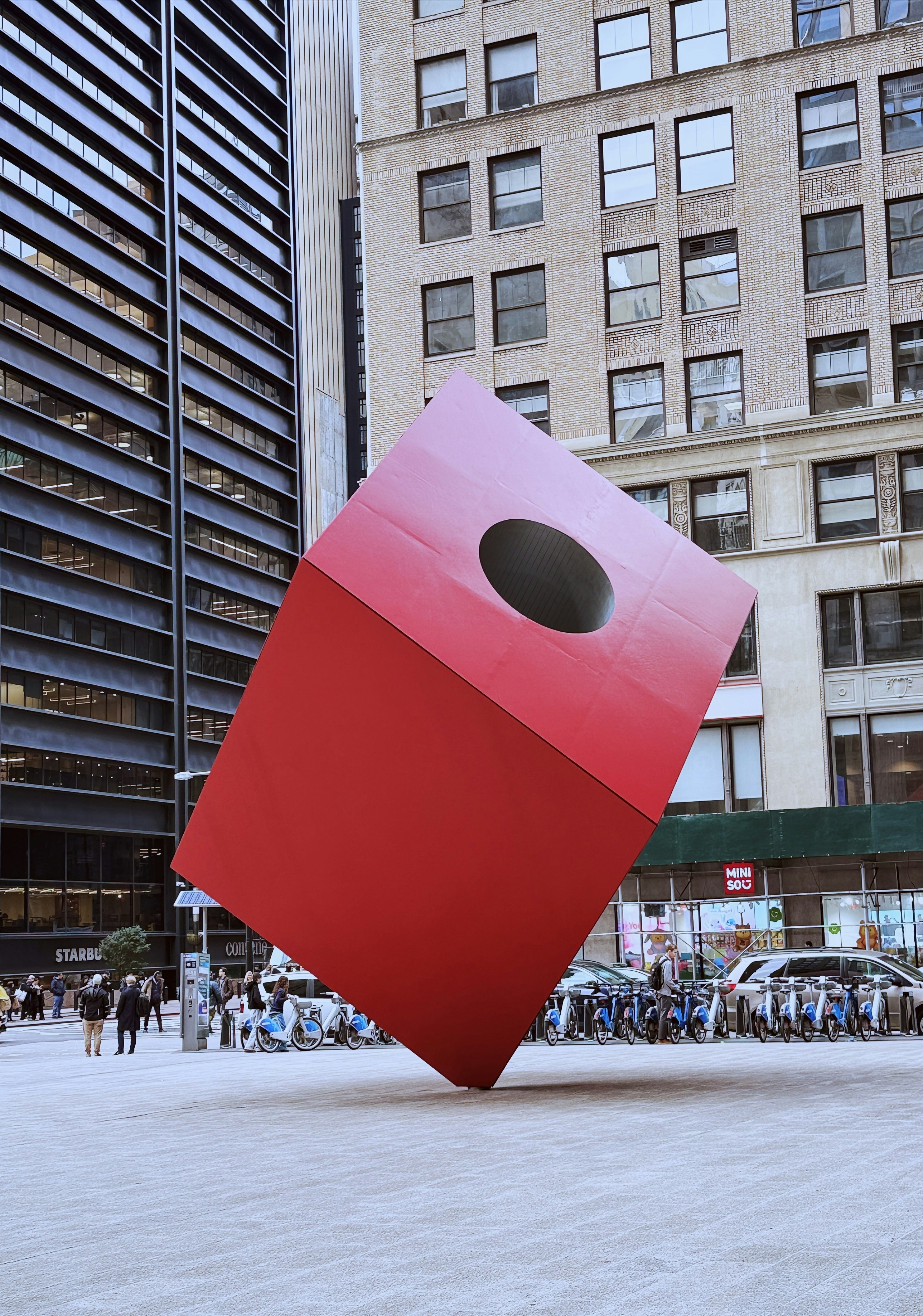 A bright red sculpture stands in an urban plaza. photo – Free Car Image ...