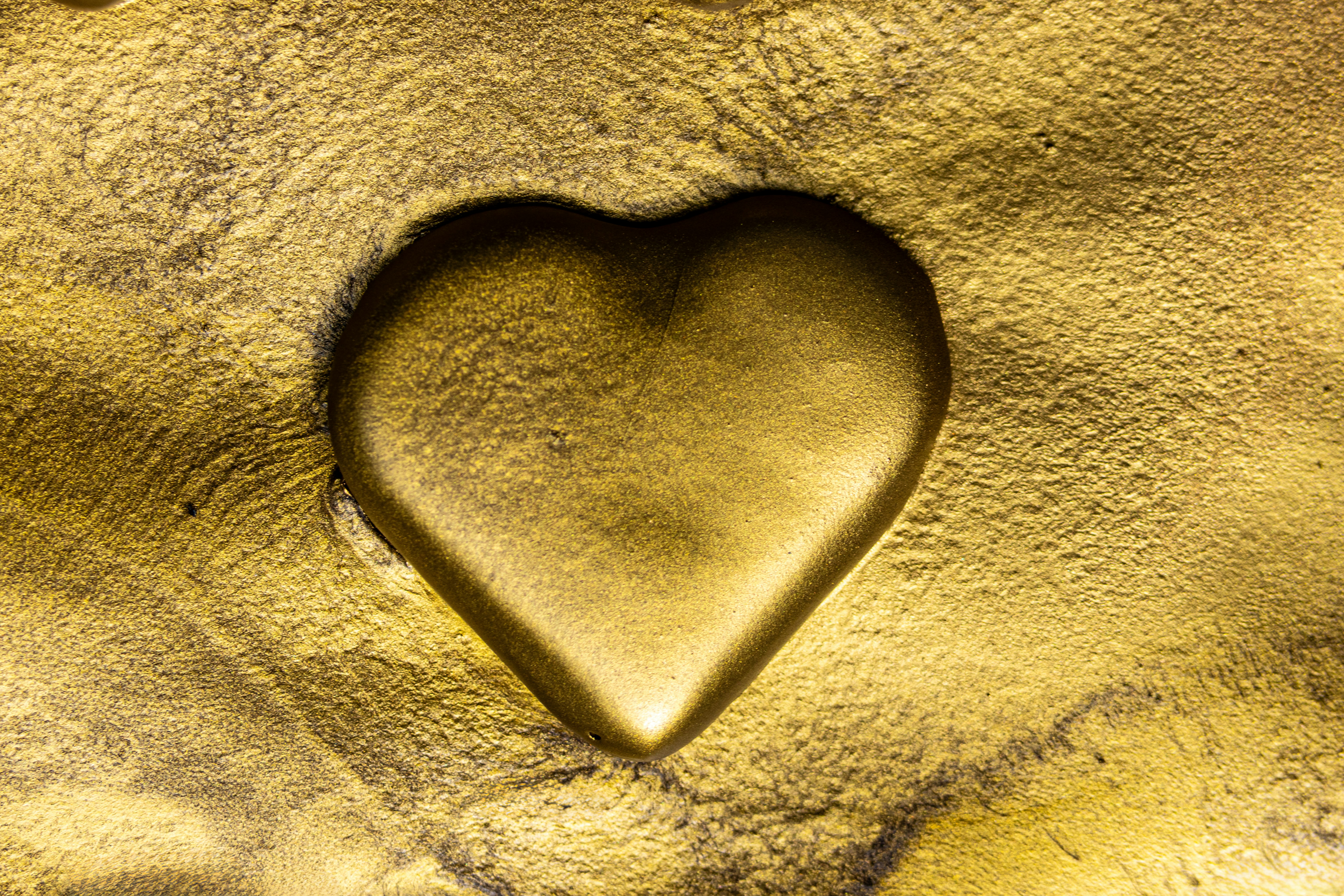 A heart-shaped motif nestled in a textured golden surface, exuding warmth and richness.