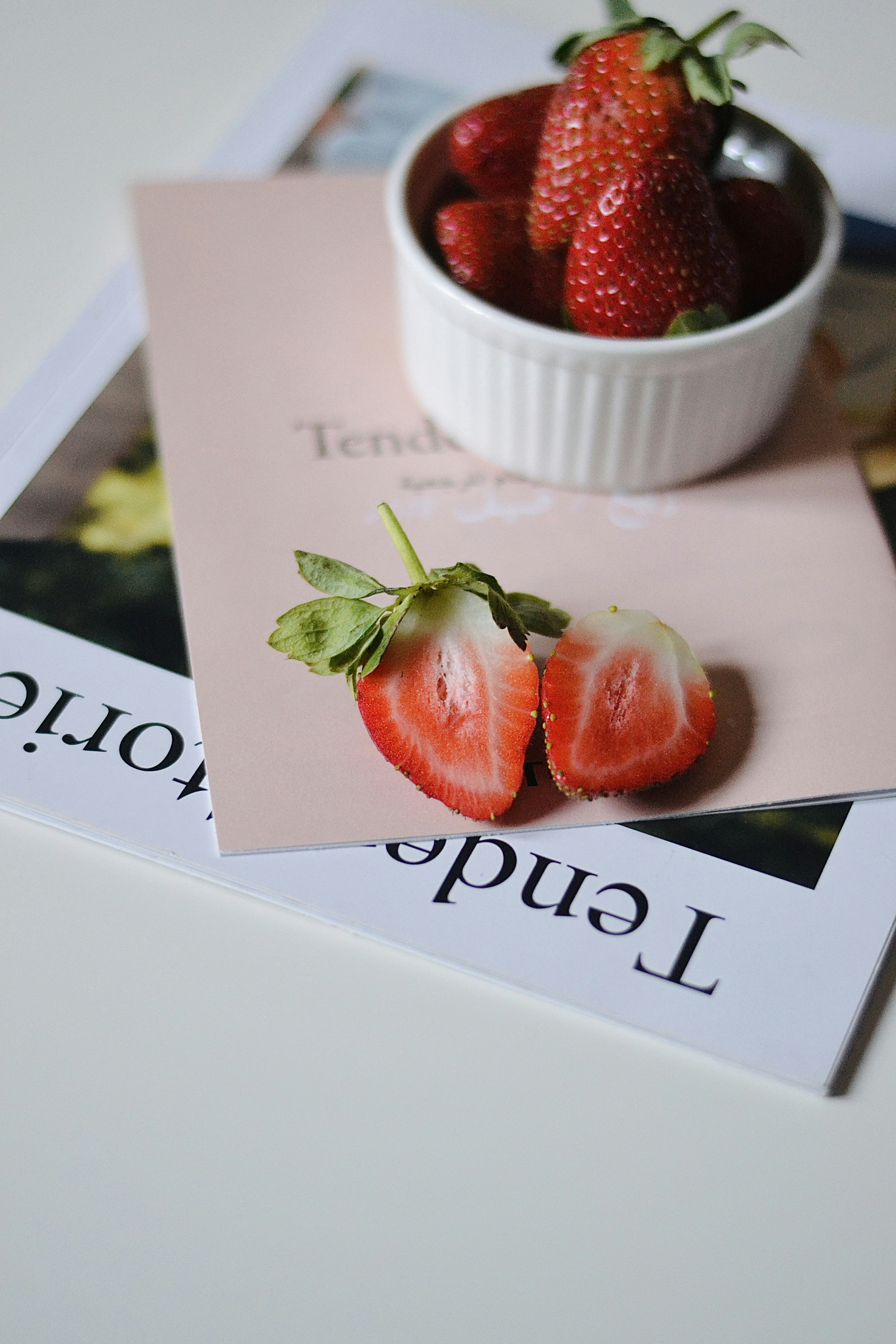 Fresh strawberries in a bowl and sliced.