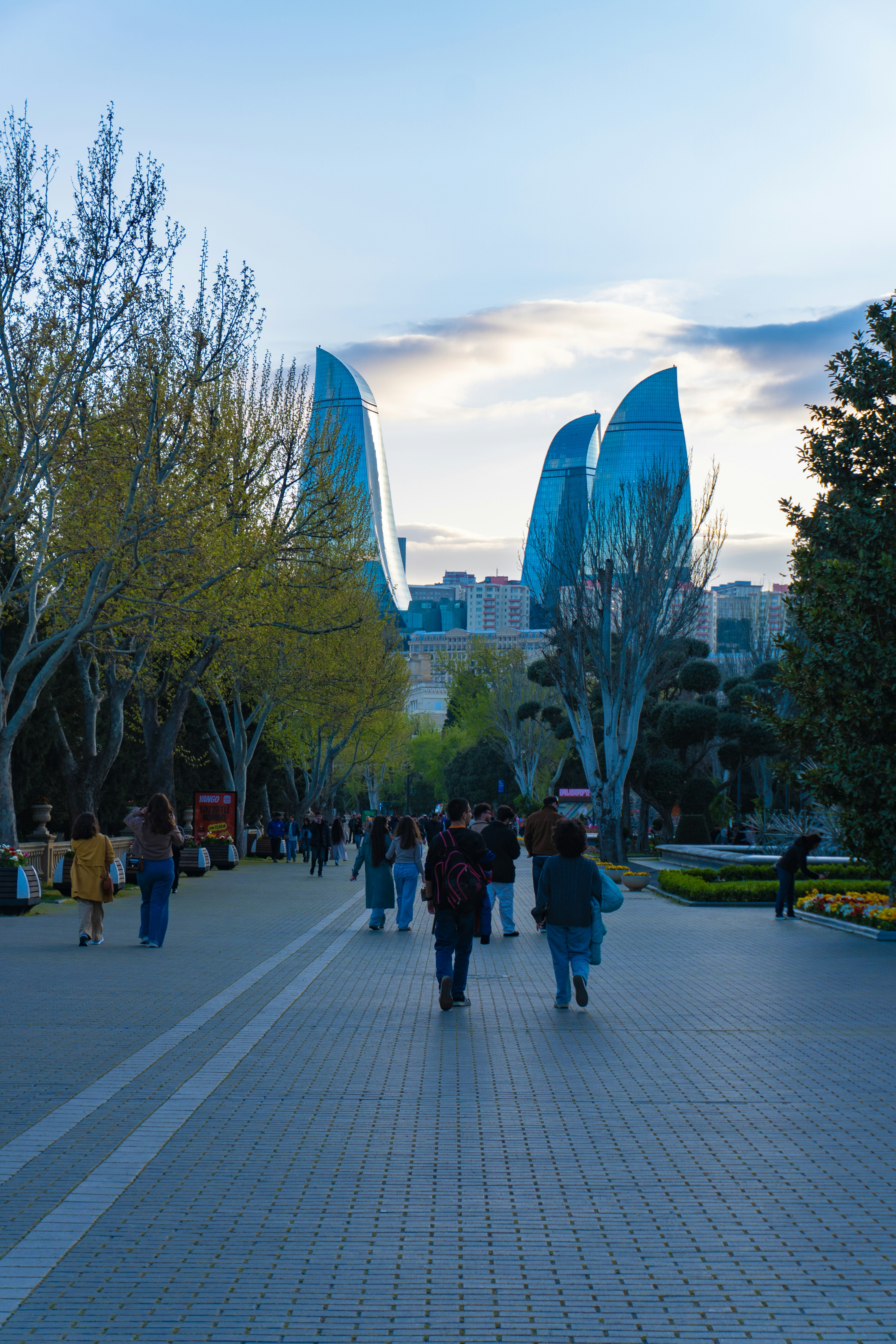People stroll along a pathway with iconic towers. photo – Free Flower ...