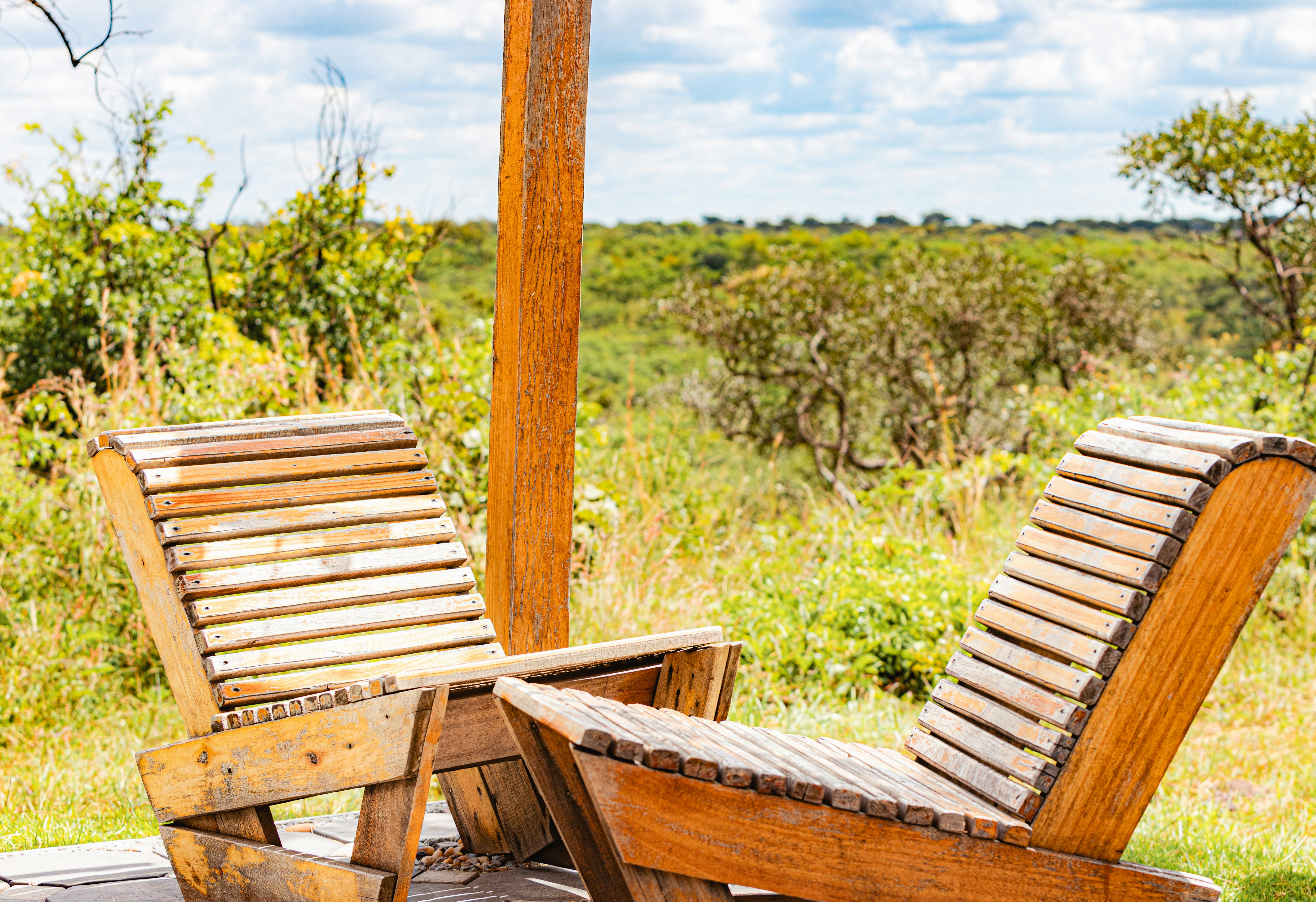 Two Weathered Adirondack Chairs in a Sunlit Prairie Outlook
