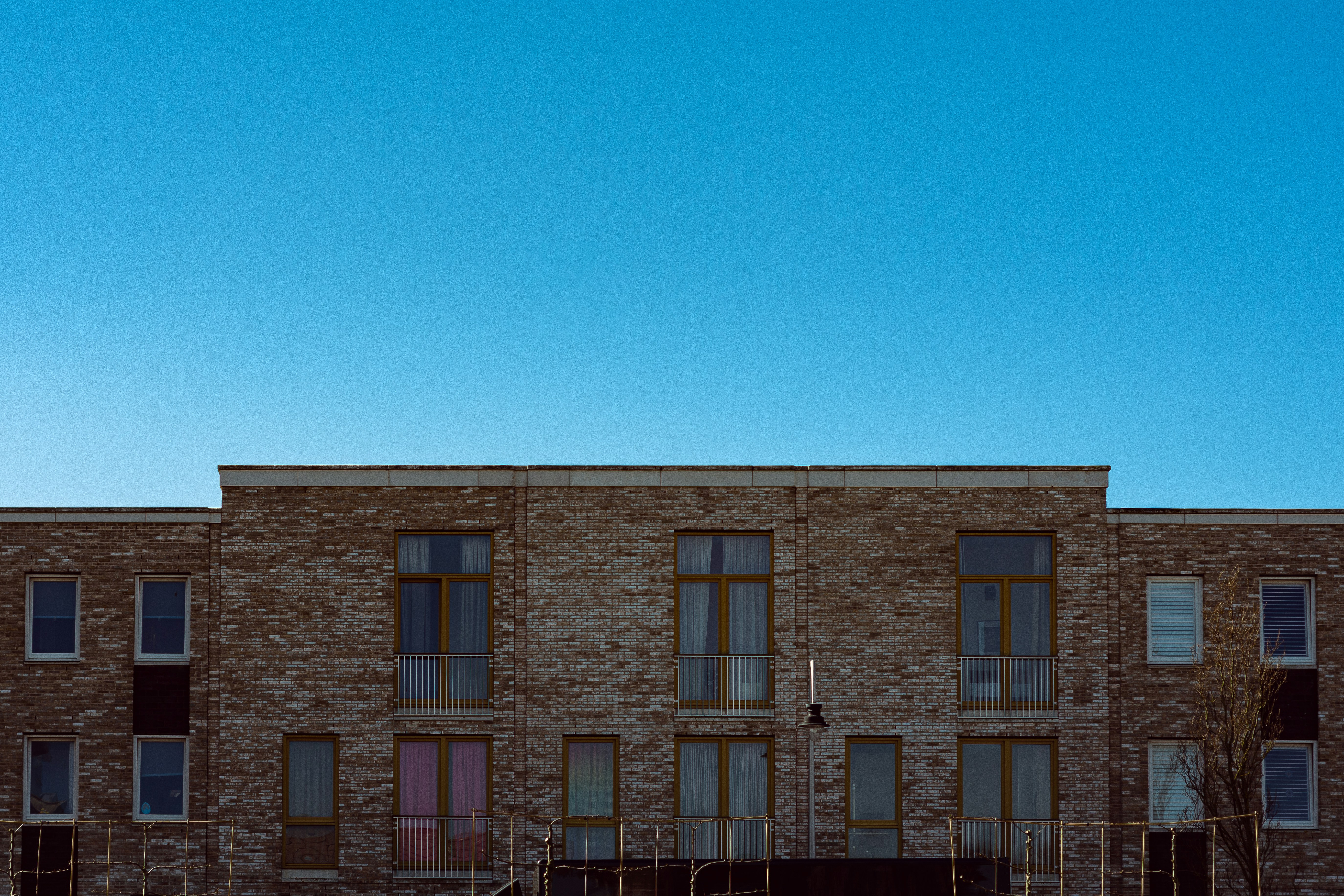 Brick building stands beneath a clear blue sky. photo – Free Building ...