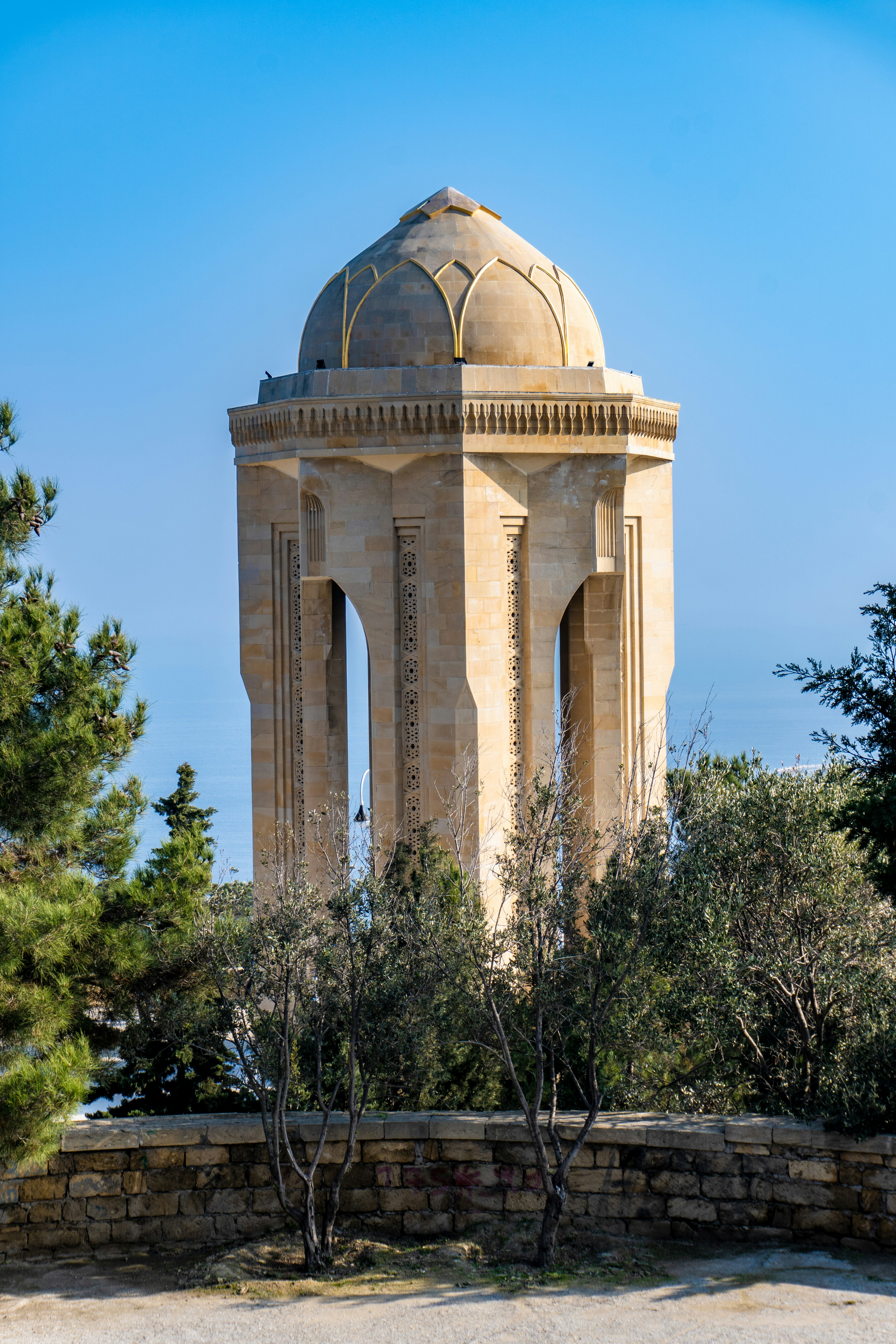 Dome-Topped Stone Tower Rising Above Scrub with a Sea-Blue Horizon