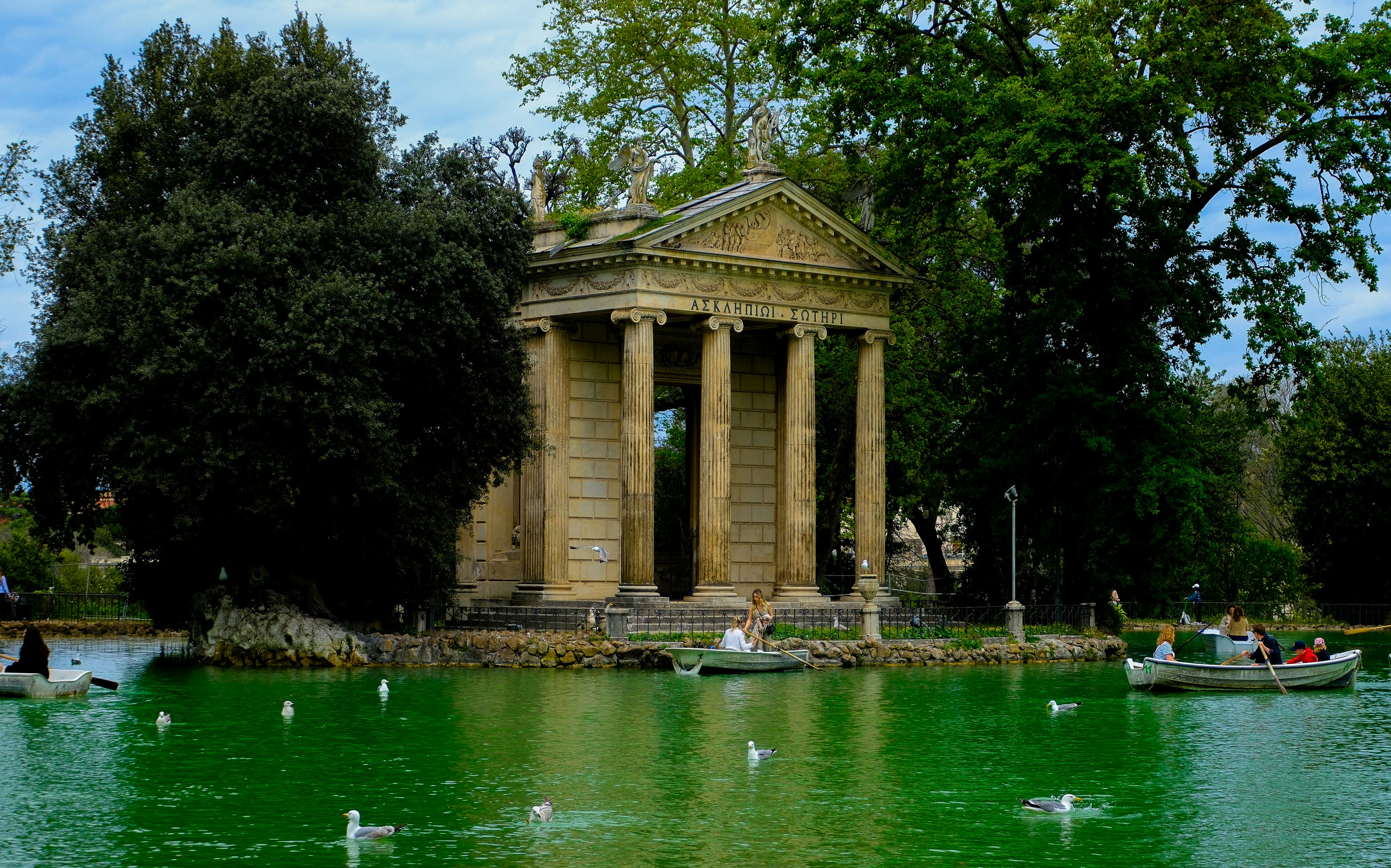 A classical temple sits on a lake.