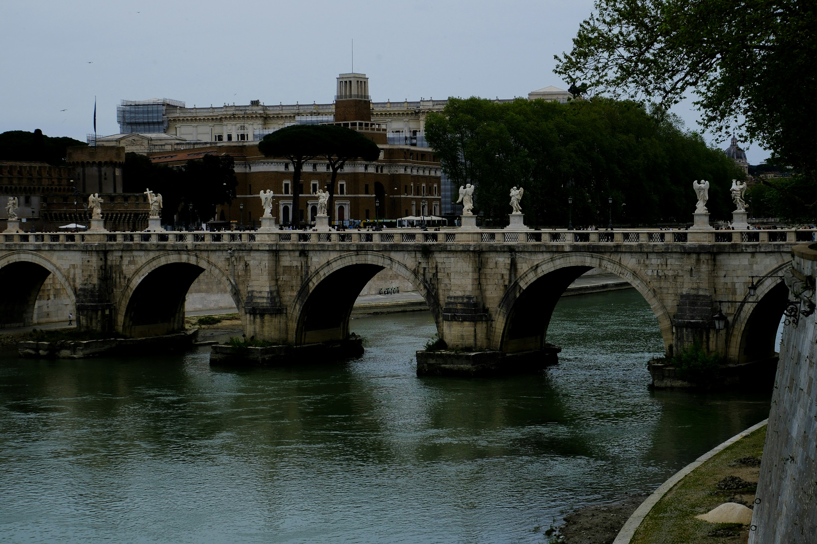 A stone bridge over a green river.
