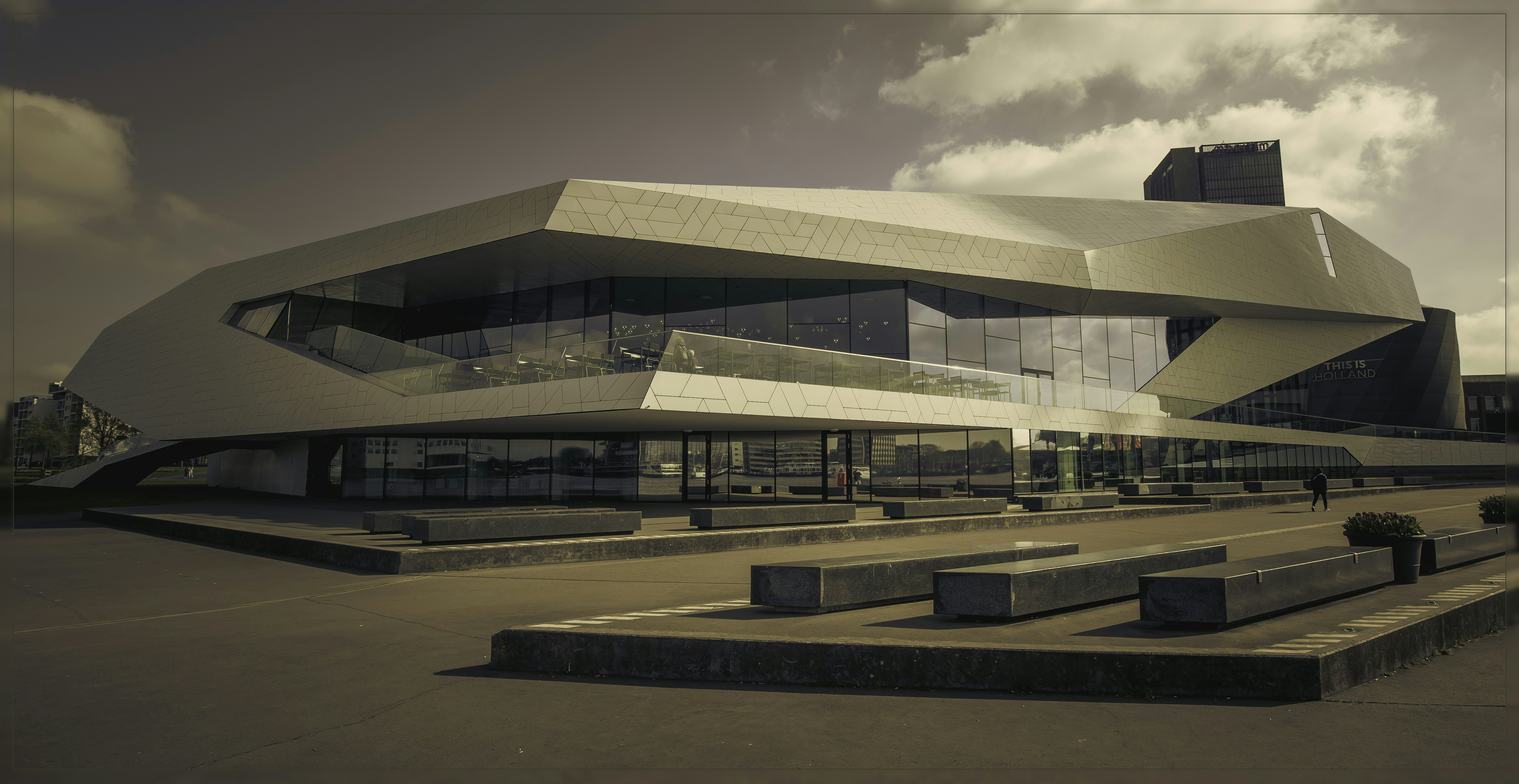 A modern, angular building stands prominently. photo – Free Building ...