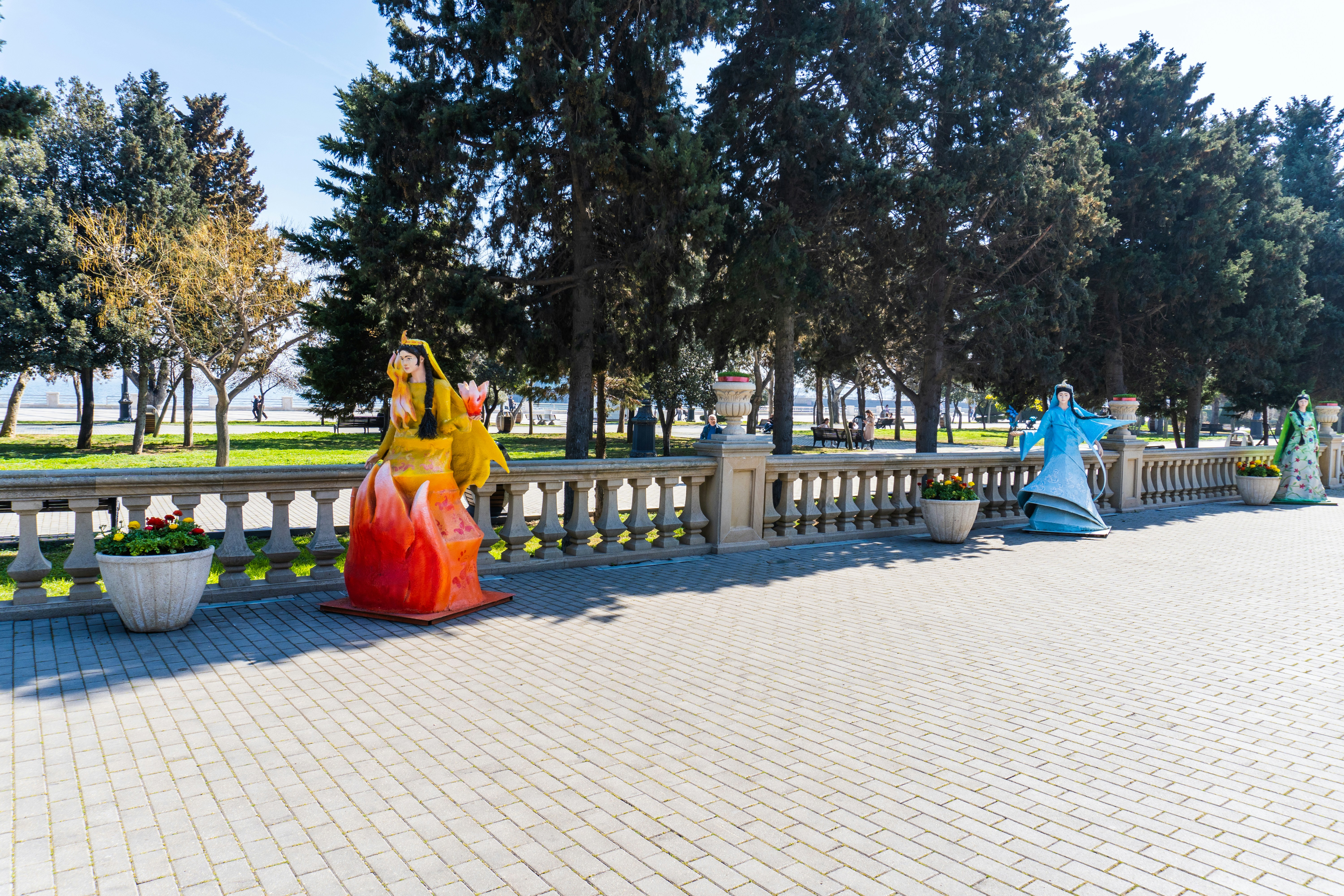 Colorful statues stand along a paved walkway. photo – Free Travel Image ...