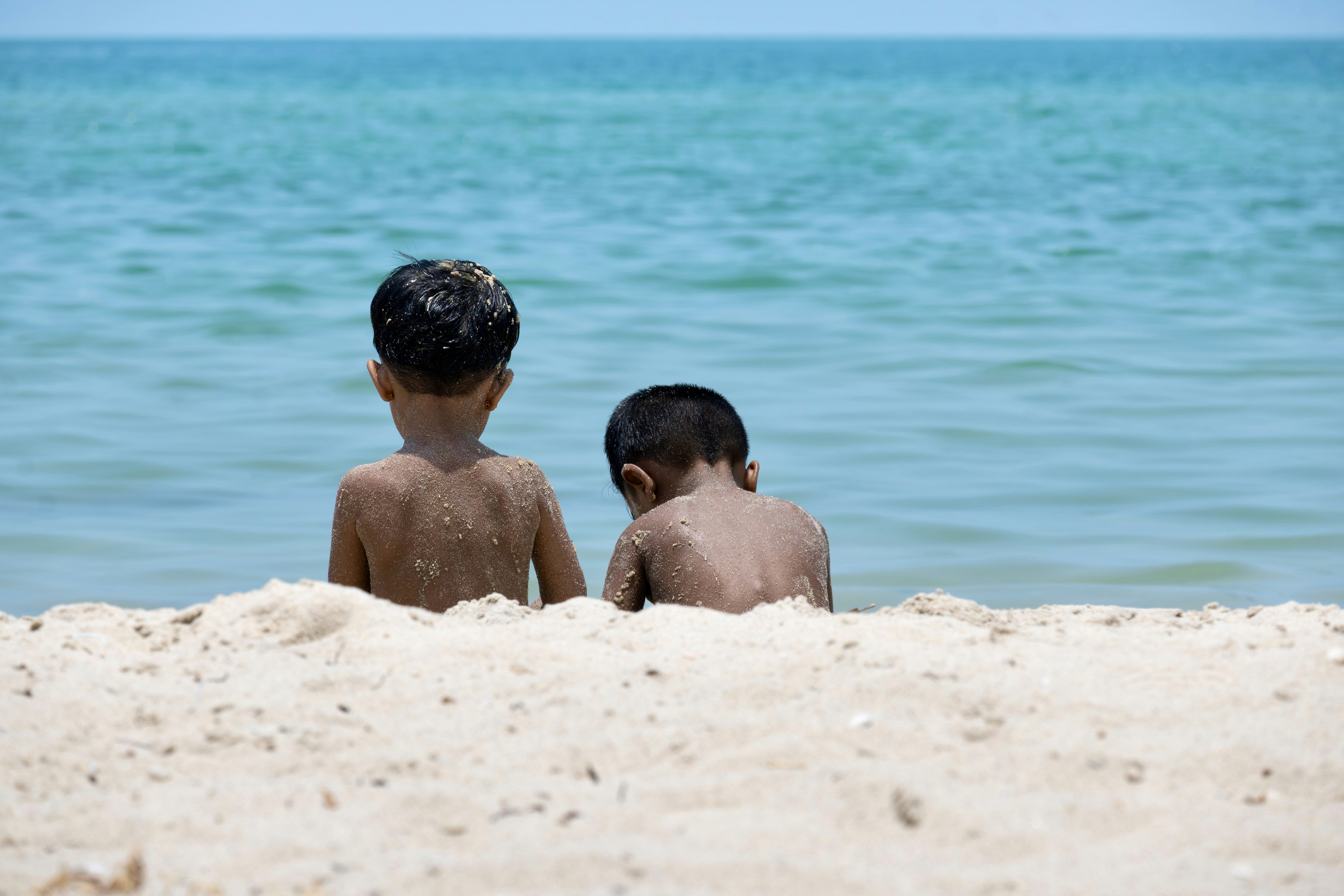 Two young boys sit at the beach. photo – Free Travel Image on Unsplash