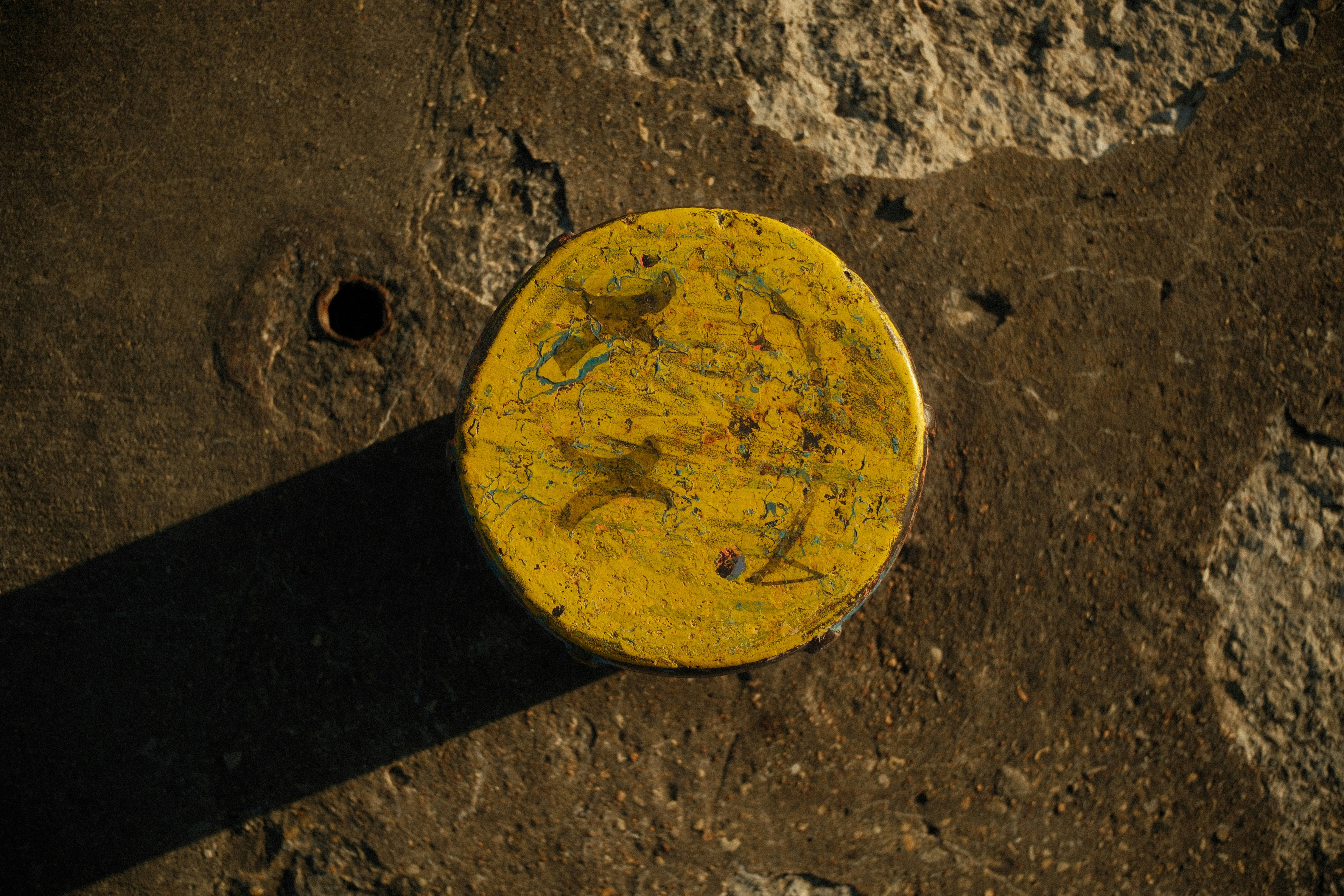 A yellow disc with drawings on a concrete surface. photo – Free ...