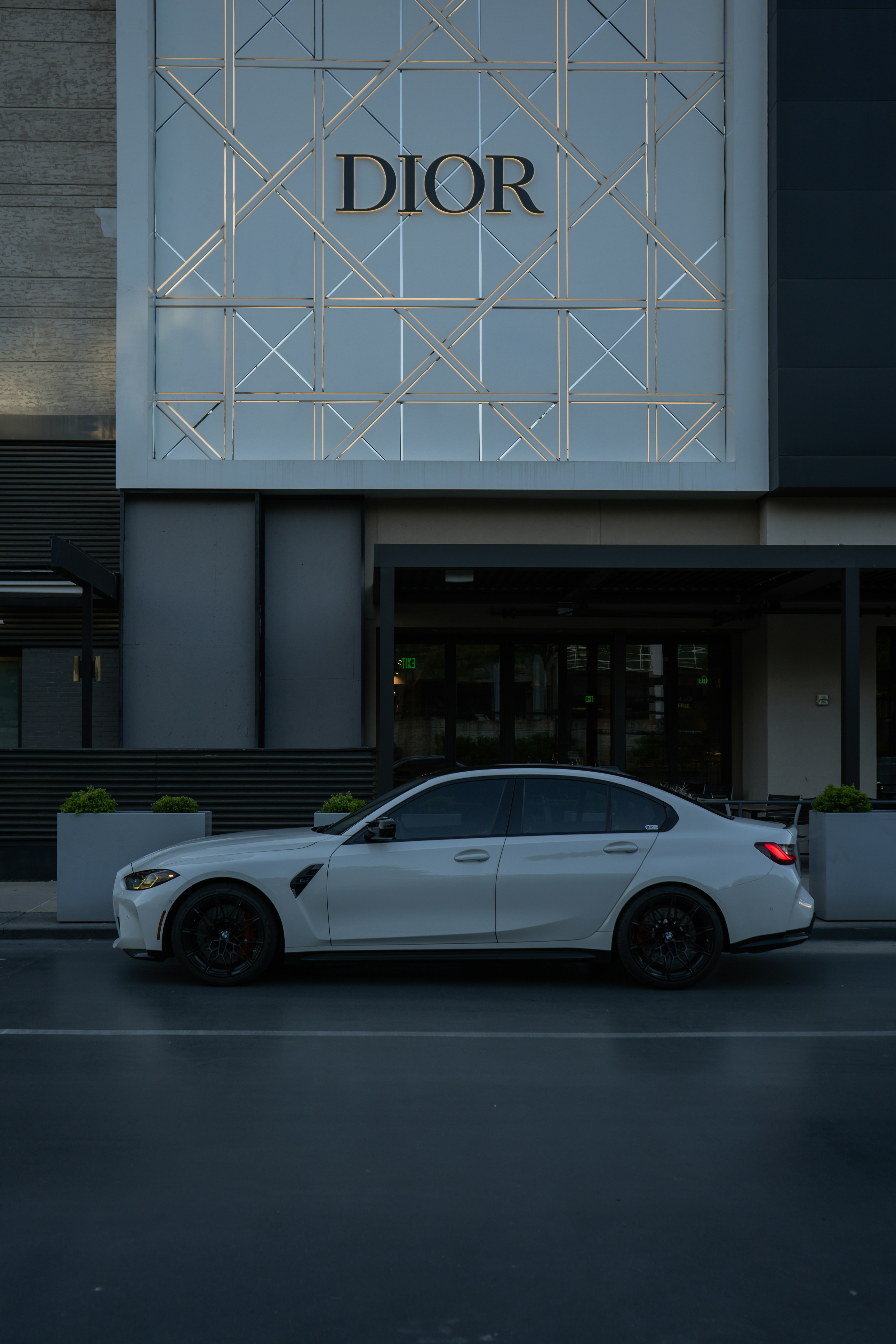 A white car parks in front of a dior store. photo – Free Car Image on ...